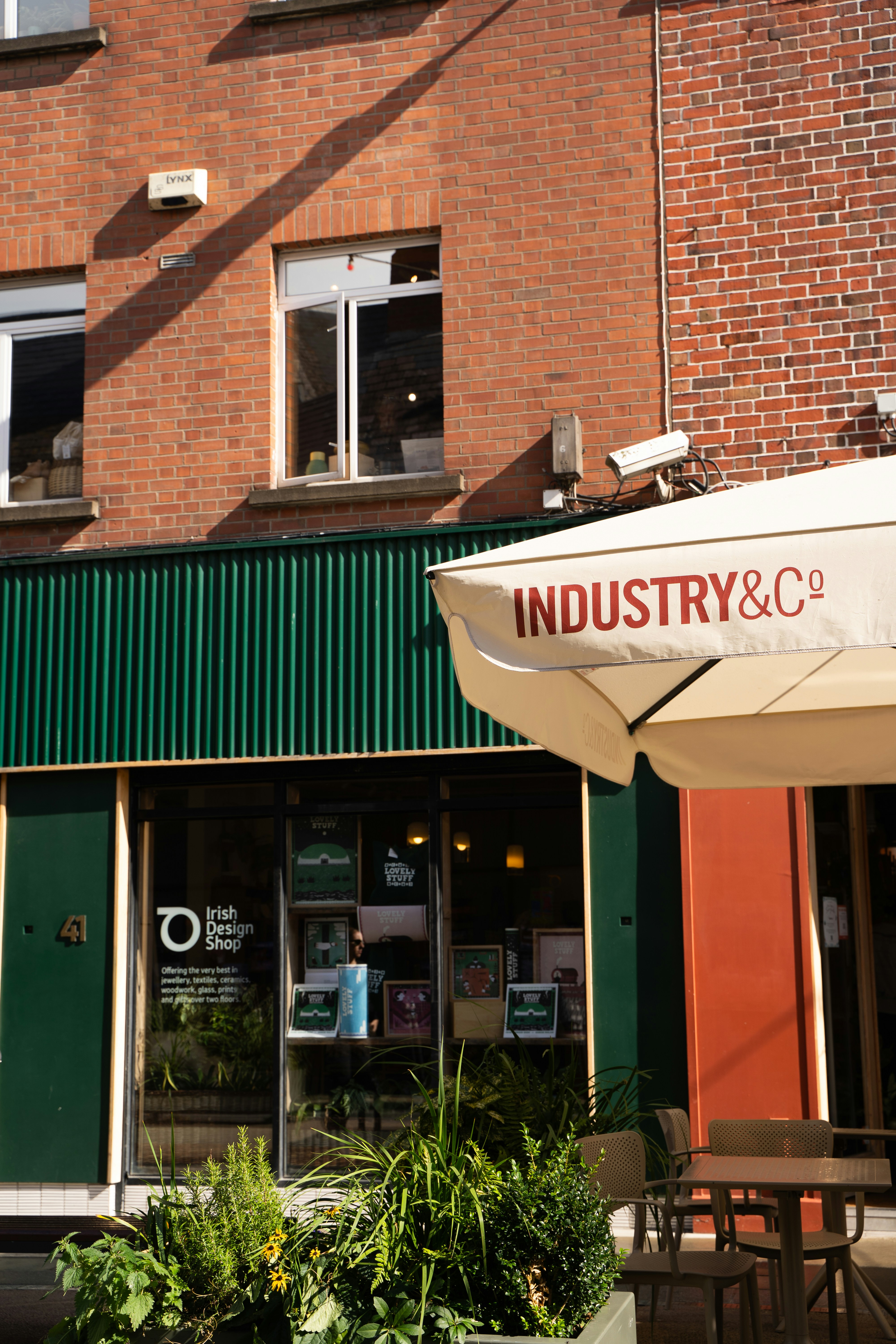 Industry & Co Umbrella Over the Irish Design Shop on a Sunlit Brick Street