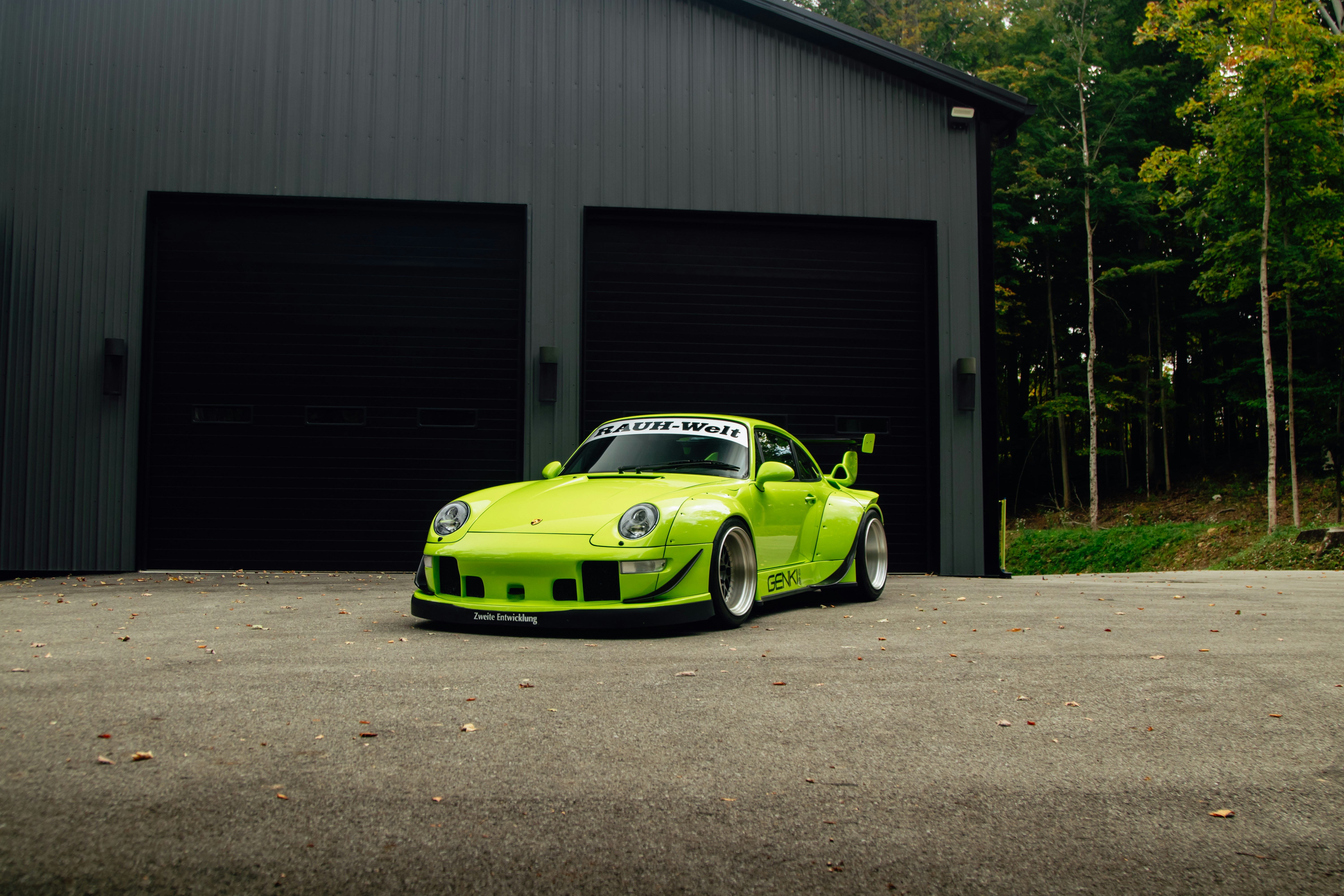Bright green sports car parked in front of garage.