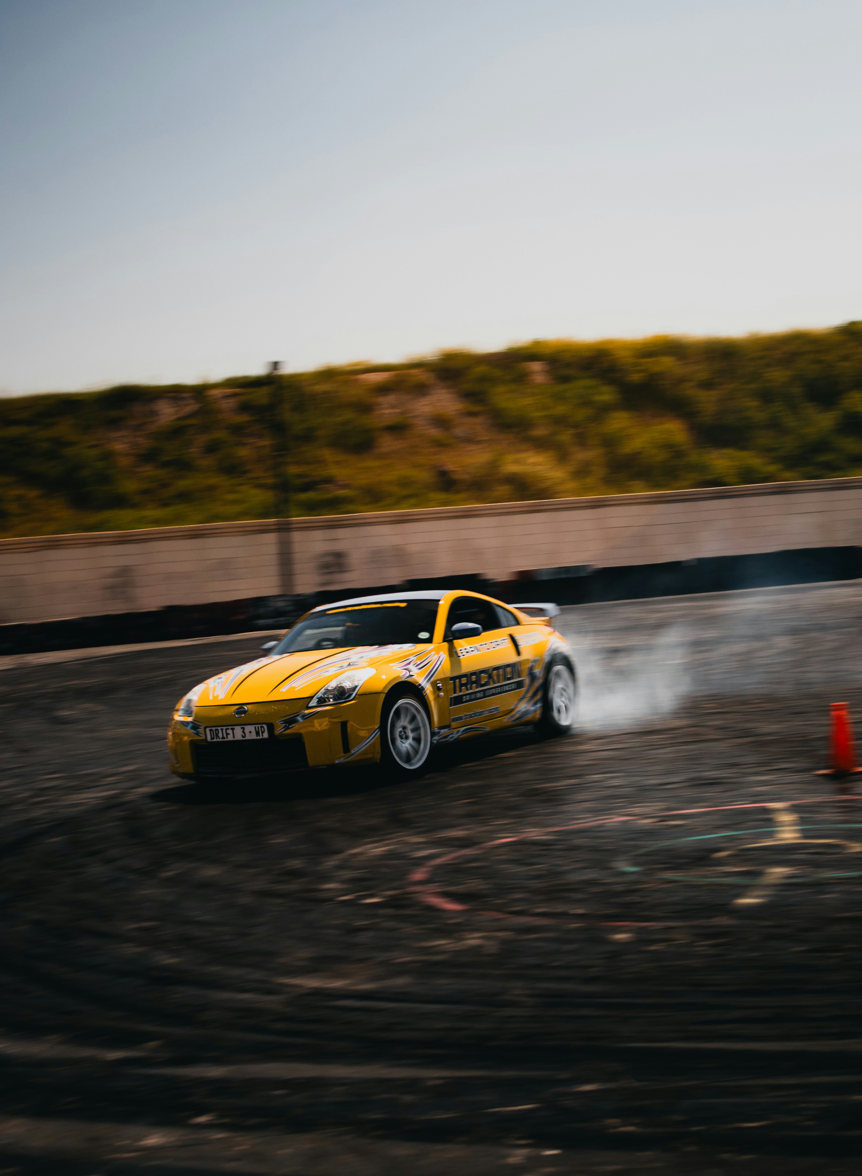 Went to a summit car race event and immediately went to the drifting competition where I captured this call during a doughnut competition with motion in the lens. | Yellow sports car drifting on asphalt track
