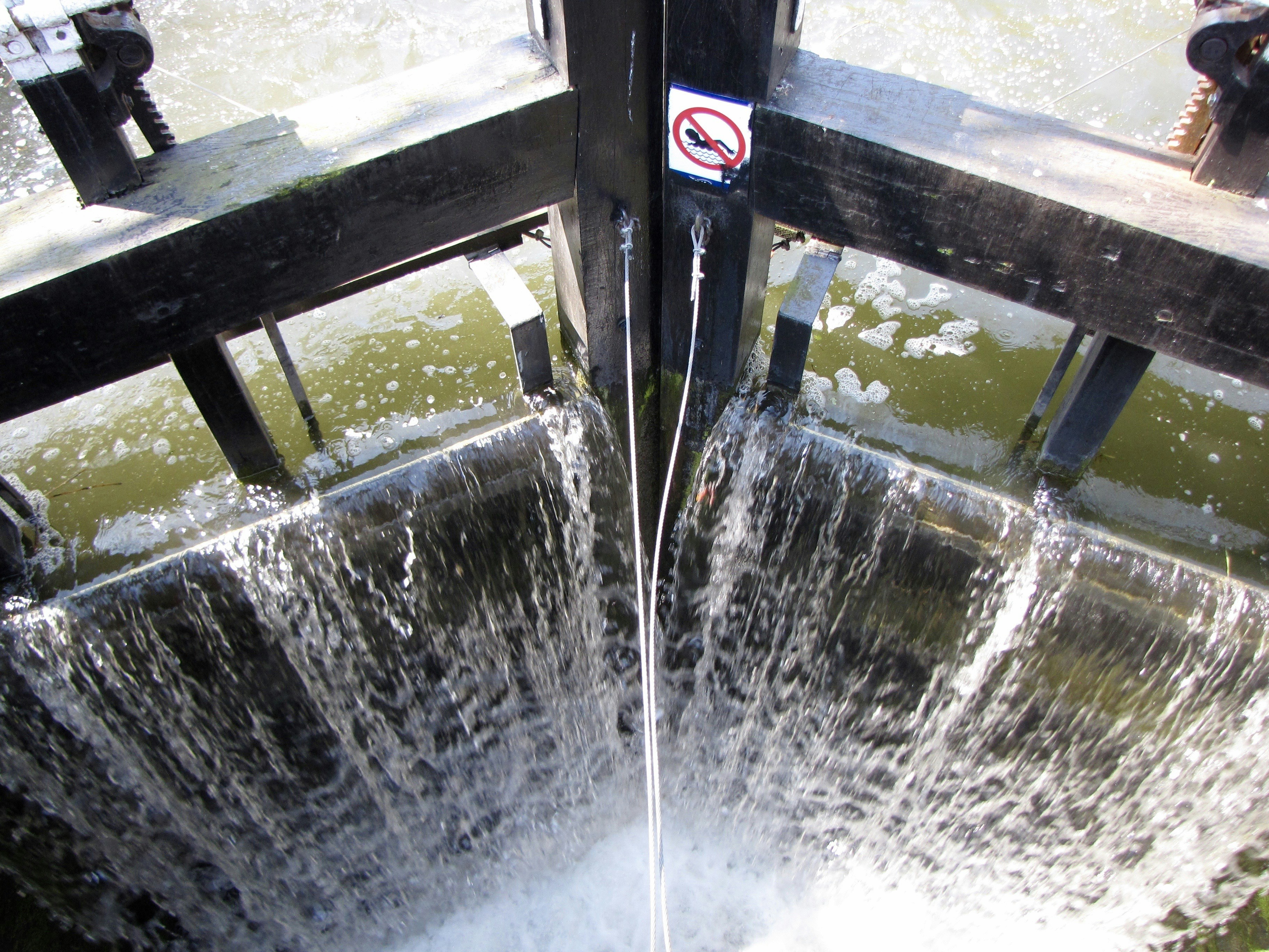 Water cascades through a lock gate mechanism, showcasing the flow dynamics and engineering involved in water navigation.