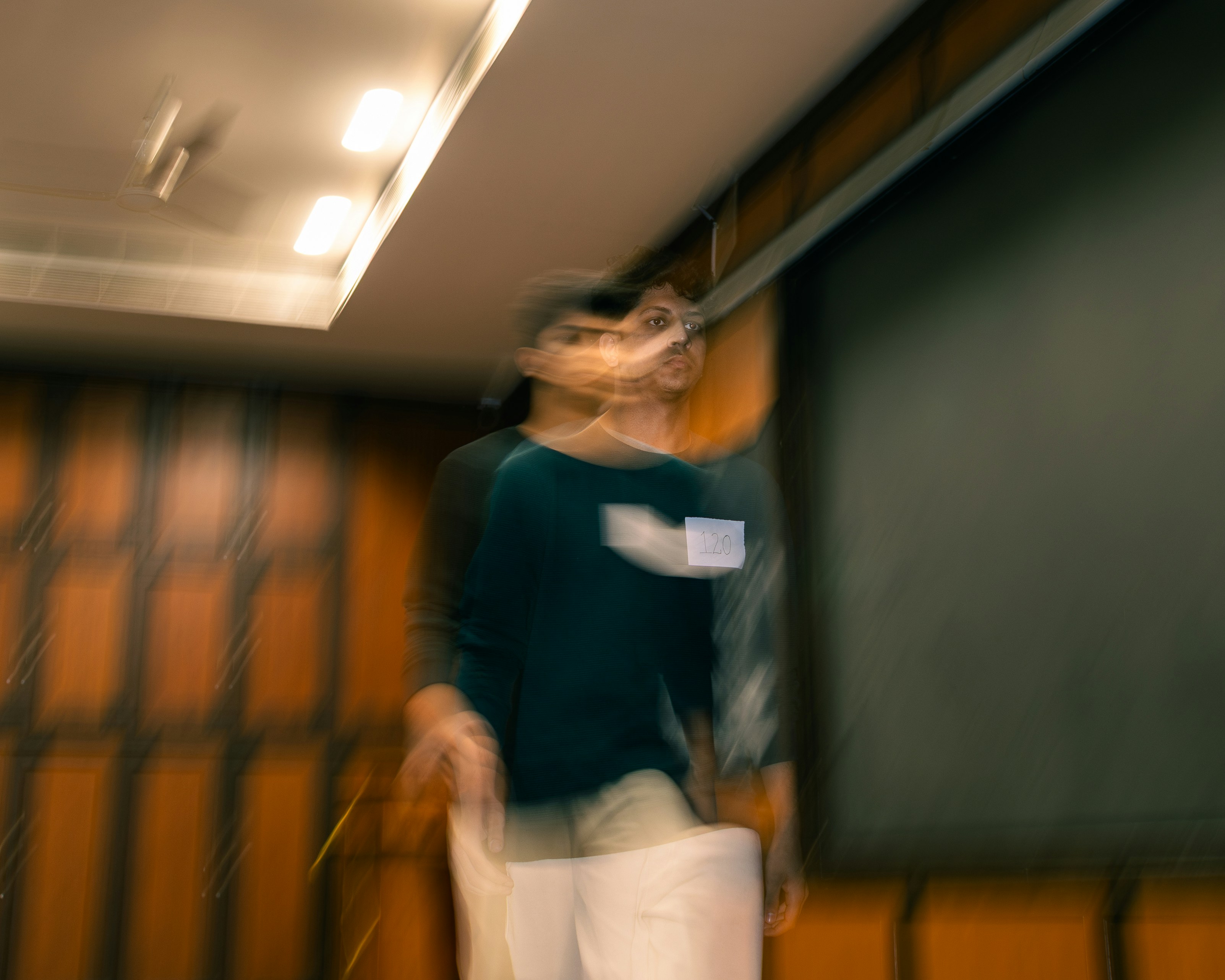 Blurred motion of a person walking indoors.