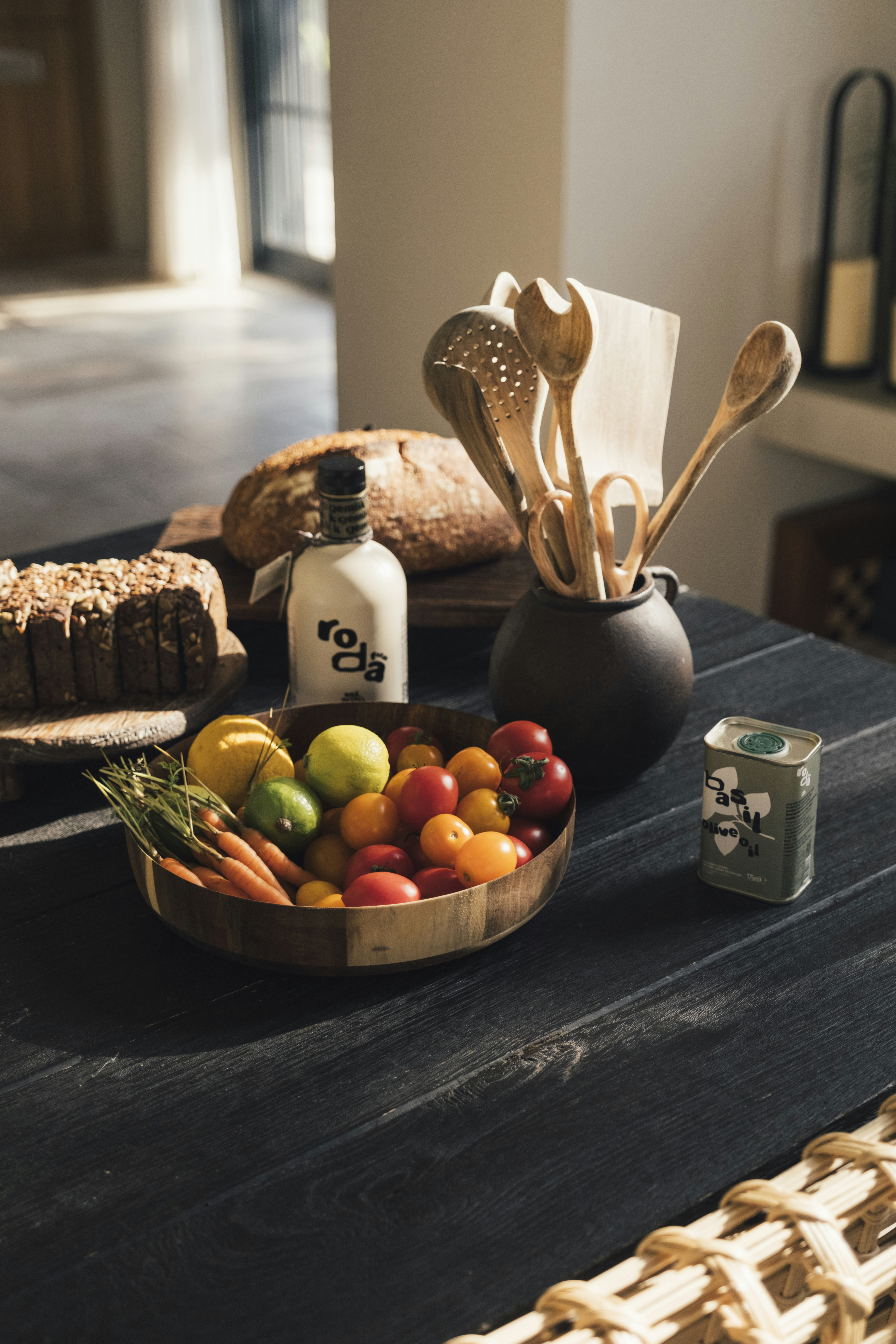 From garden to table: cherry tomatoes on the vine, baby carrots, and roasted asparagus meet artisan bread and premium infused olive oils. A warm invitation to healthy, mindful eating. | Fresh vegetables, bread, and cooking utensils on a table.