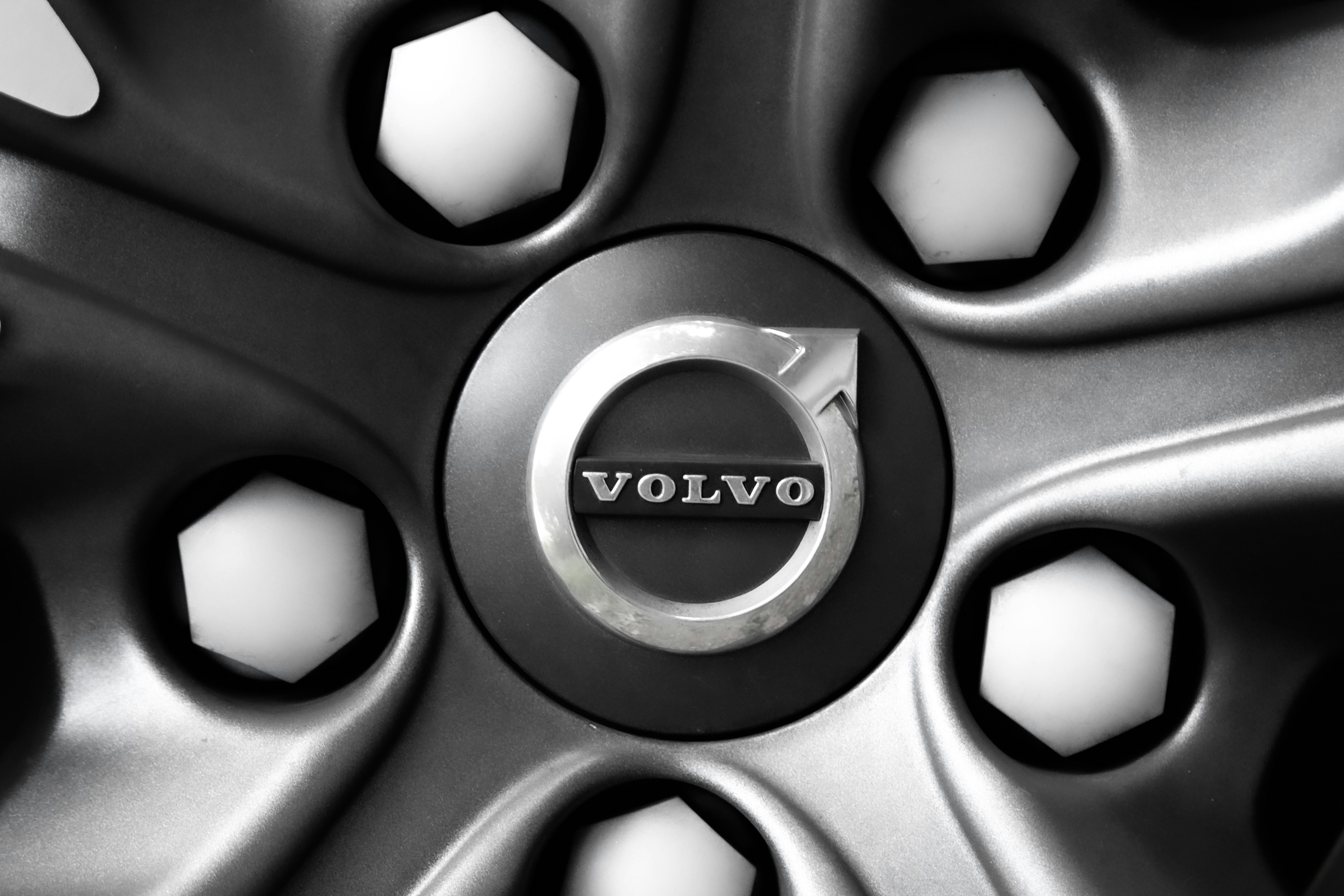 Close-up of a Volvo wheel with a prominent logo at the center, showcasing the intricate design of the rim and lug nuts.