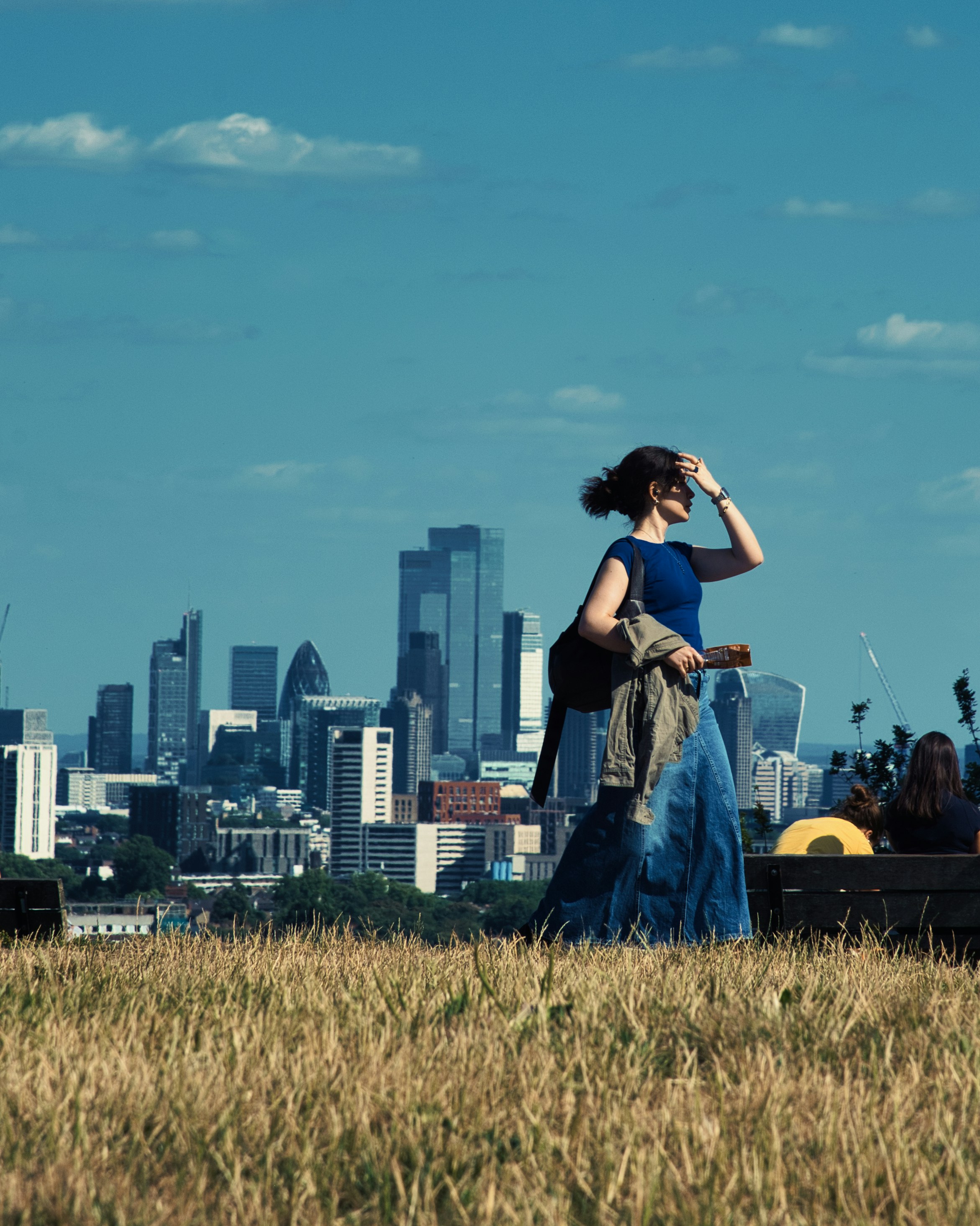 Woman walking with city skyline in background