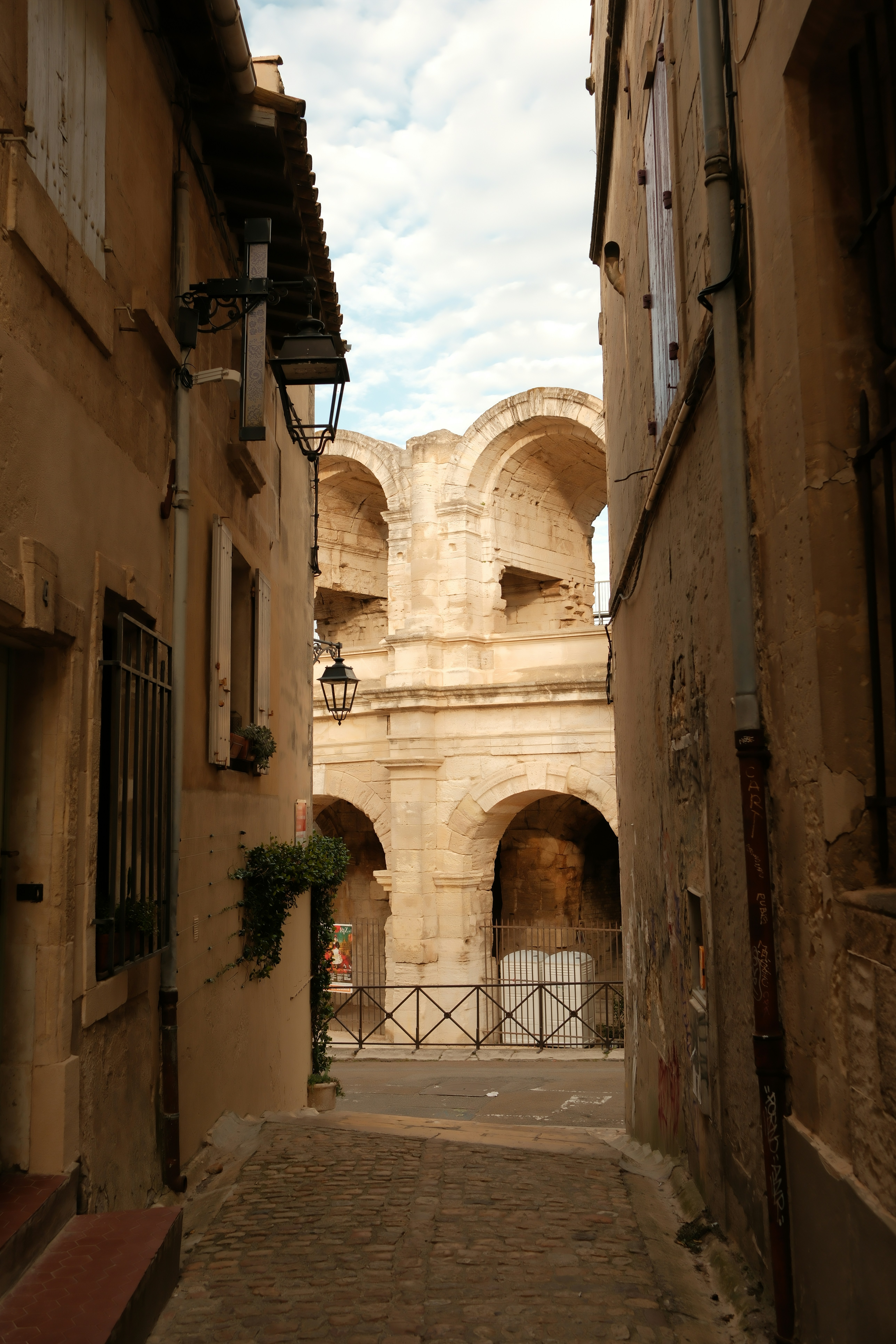 Narrow street leading to ancient roman amphitheater ruins