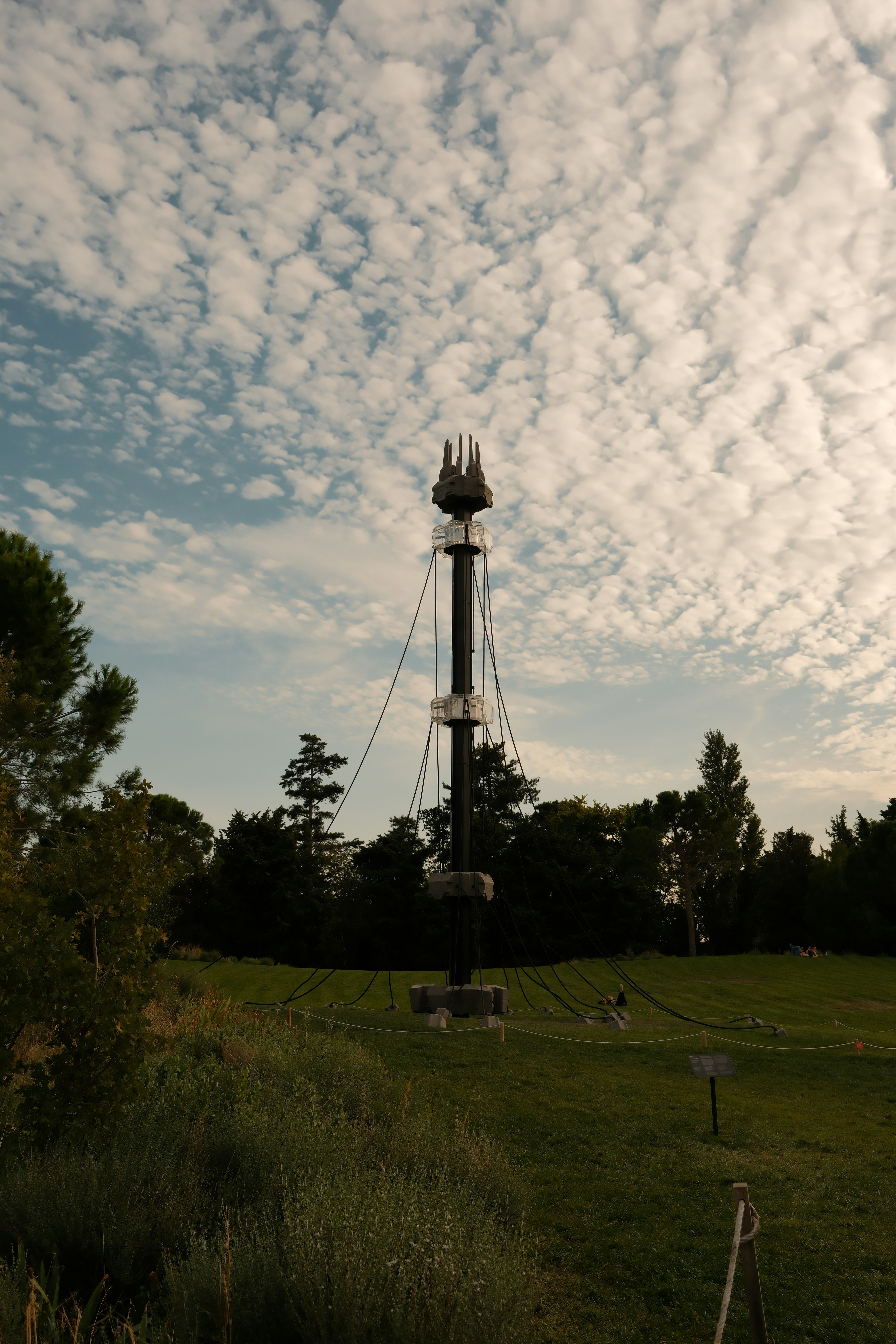 Tall structure with lights against a cloudy sky.