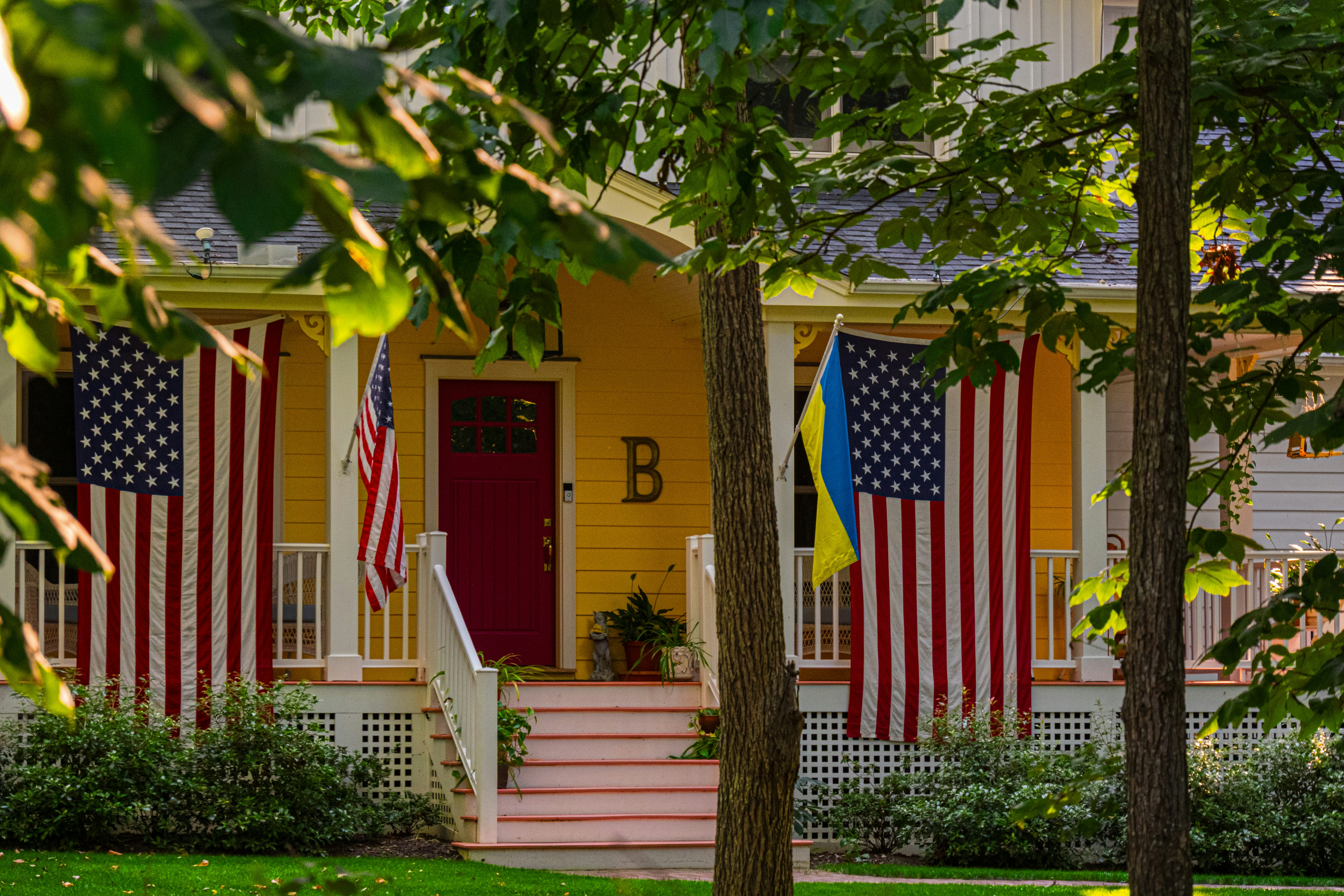 American flags decorate front porch | House decorated with american and ukrainian flags.