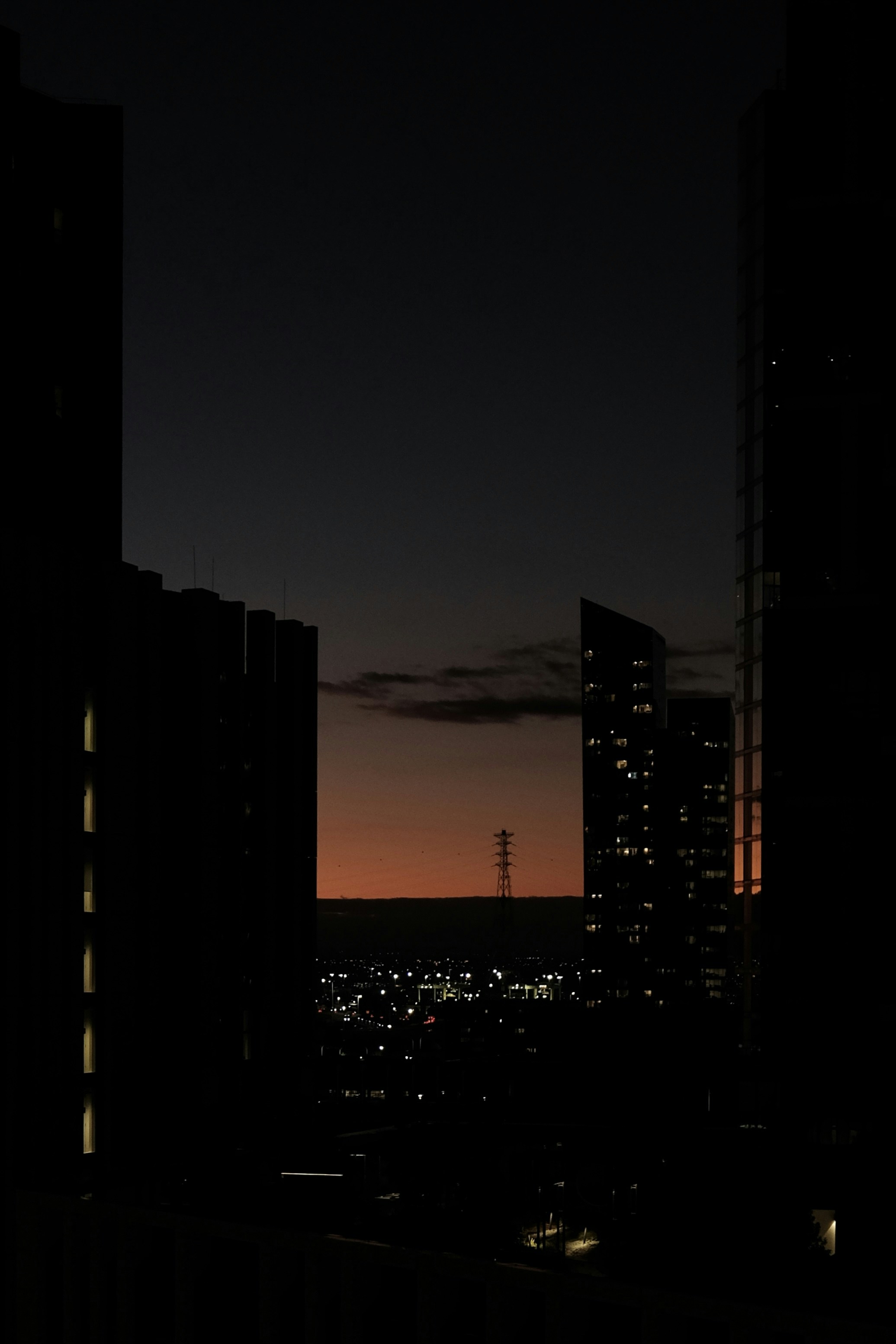 City skyline at dusk with illuminated buildings.