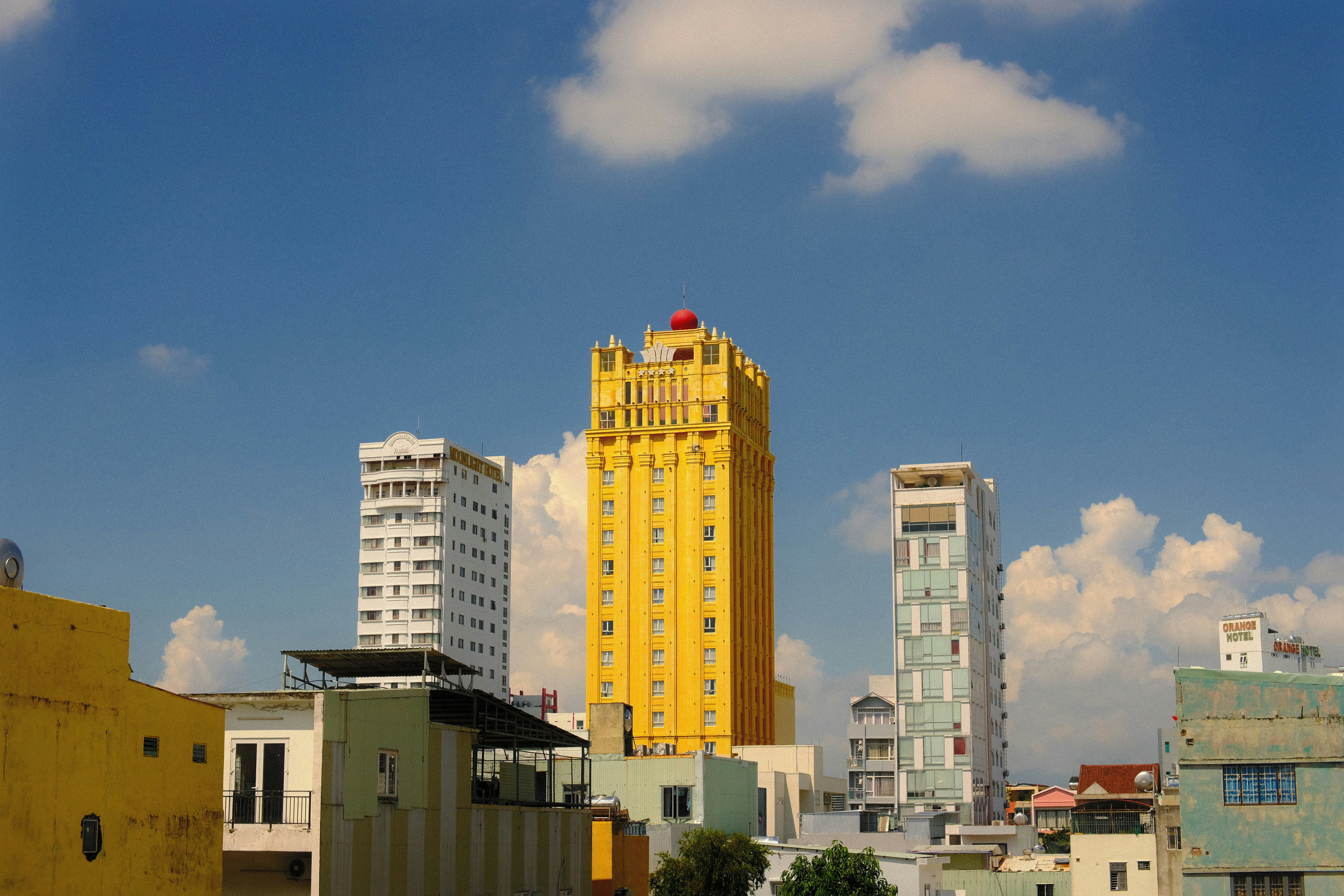 Tall buildings under a blue sky with clouds