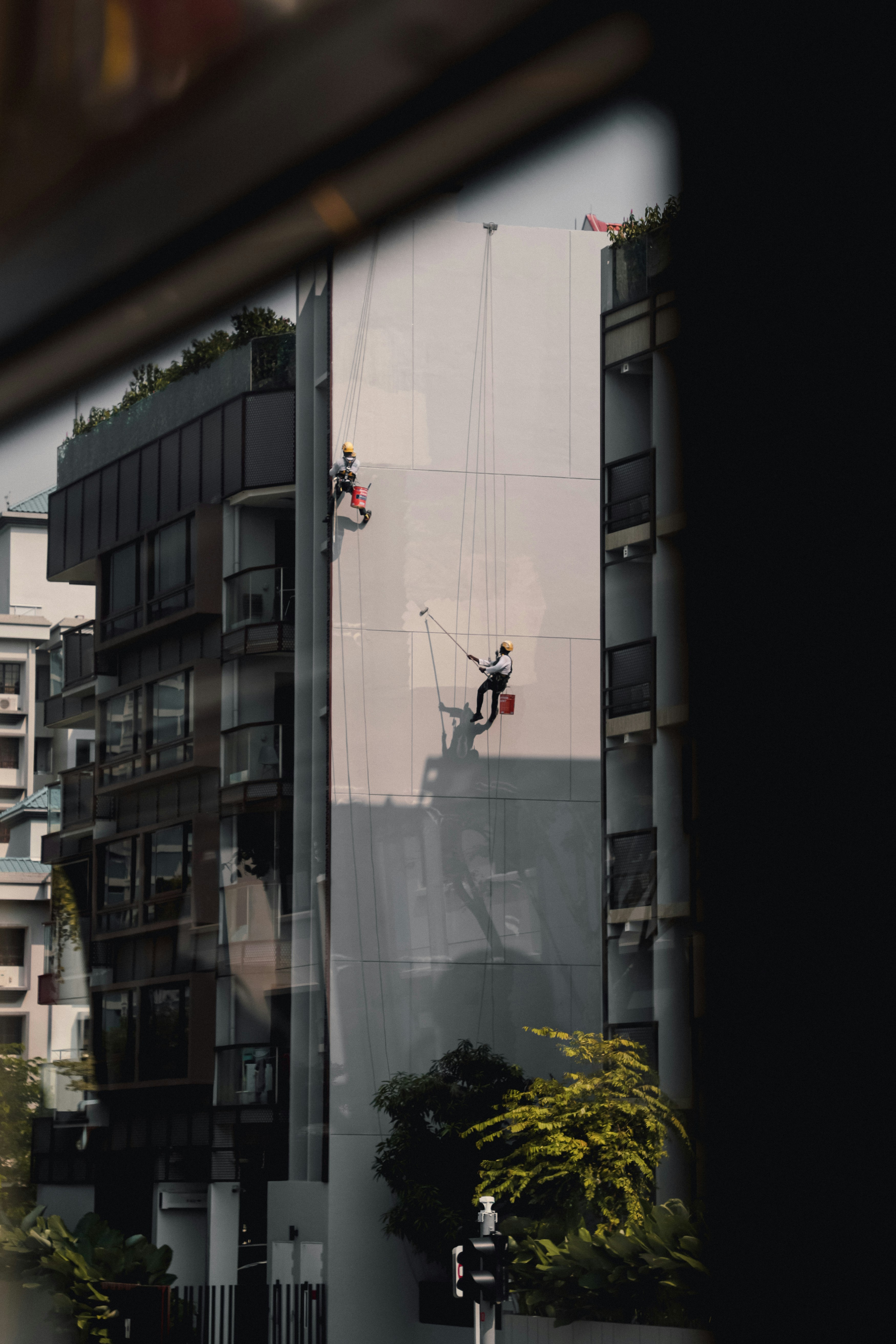 Workers cleaning the exterior of a modern building.
