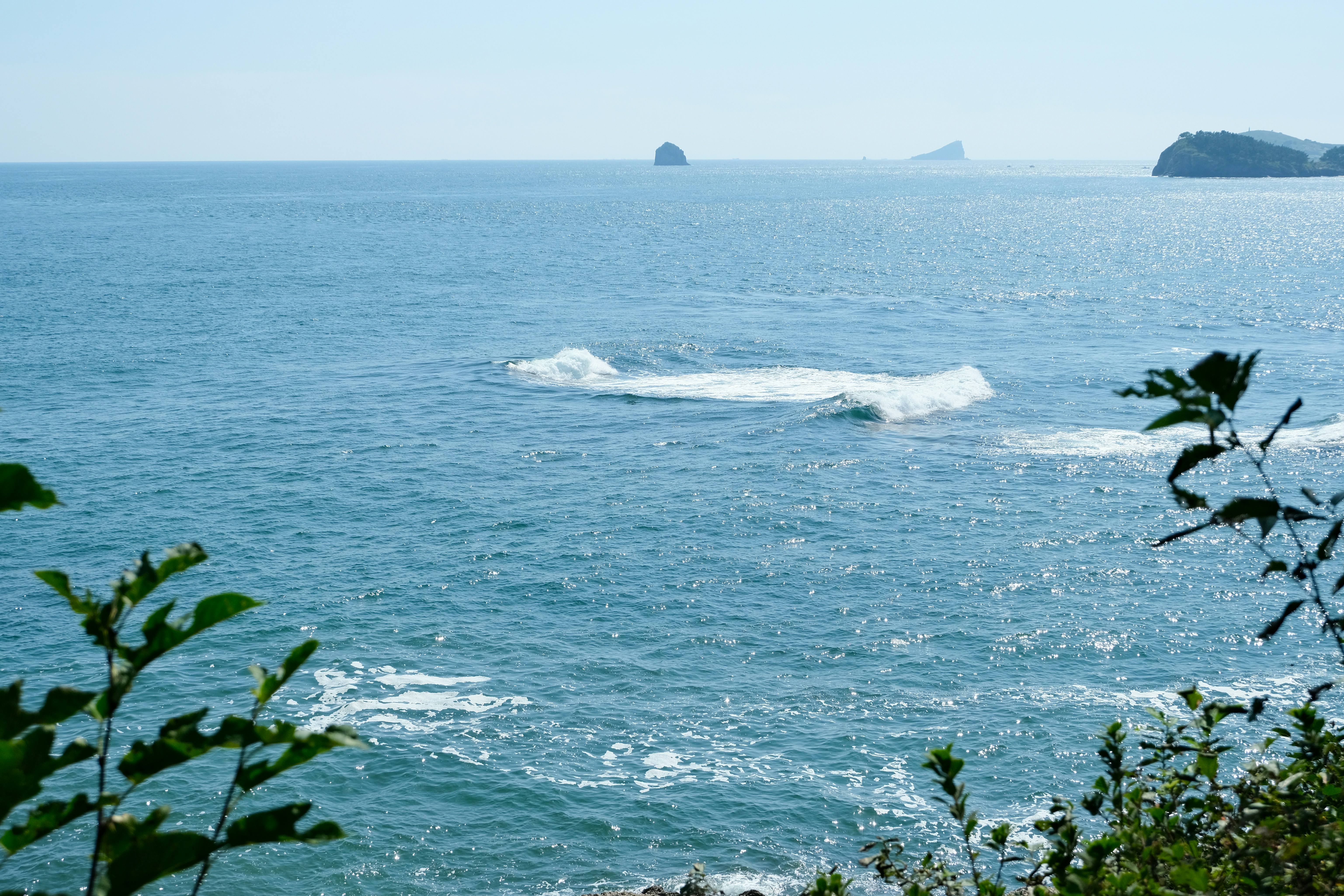 Ocean waves near a rocky coastline with distant islands photo – Free ...