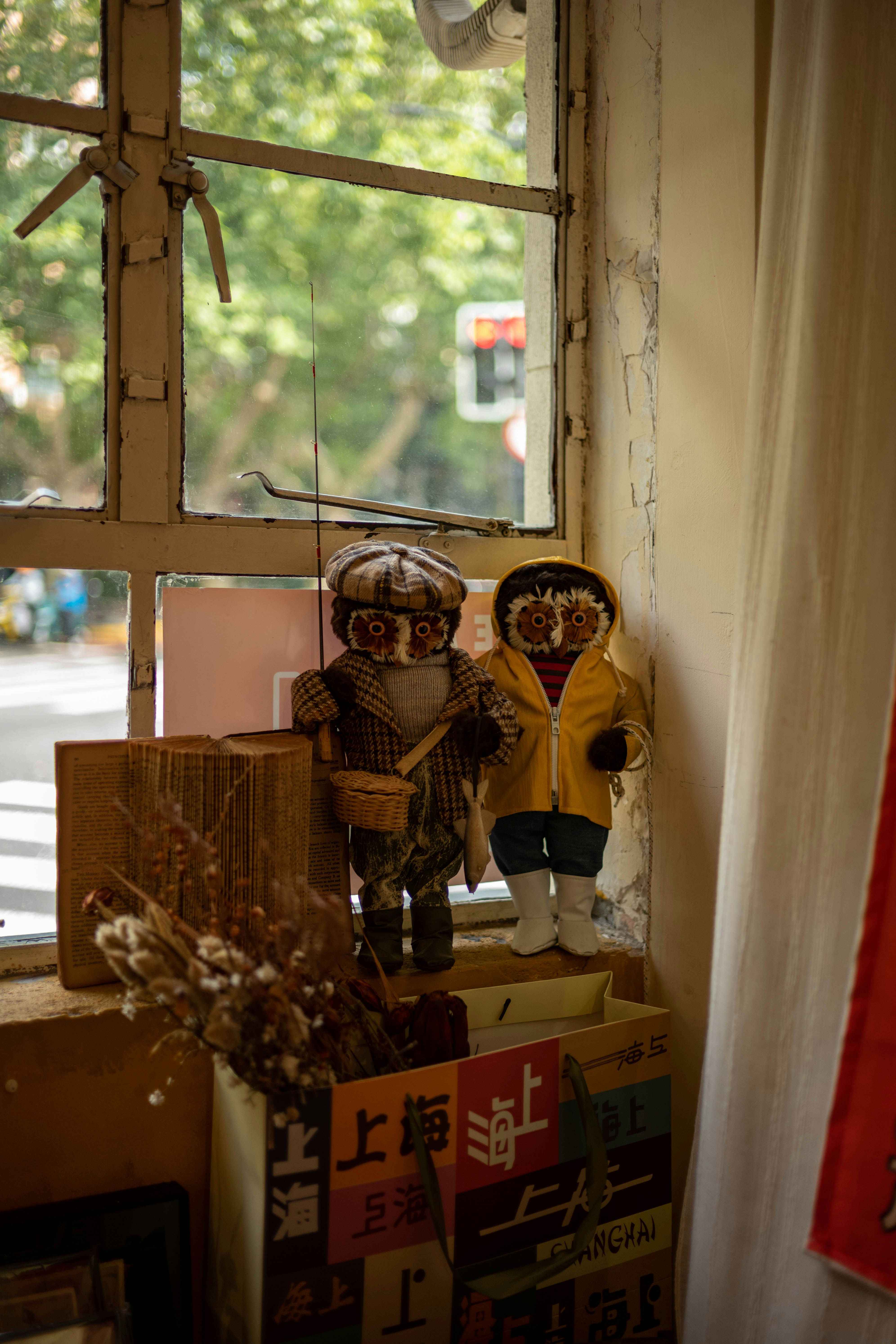 Two Owl-Faced Dolls Guard a Sunlit Windowsill