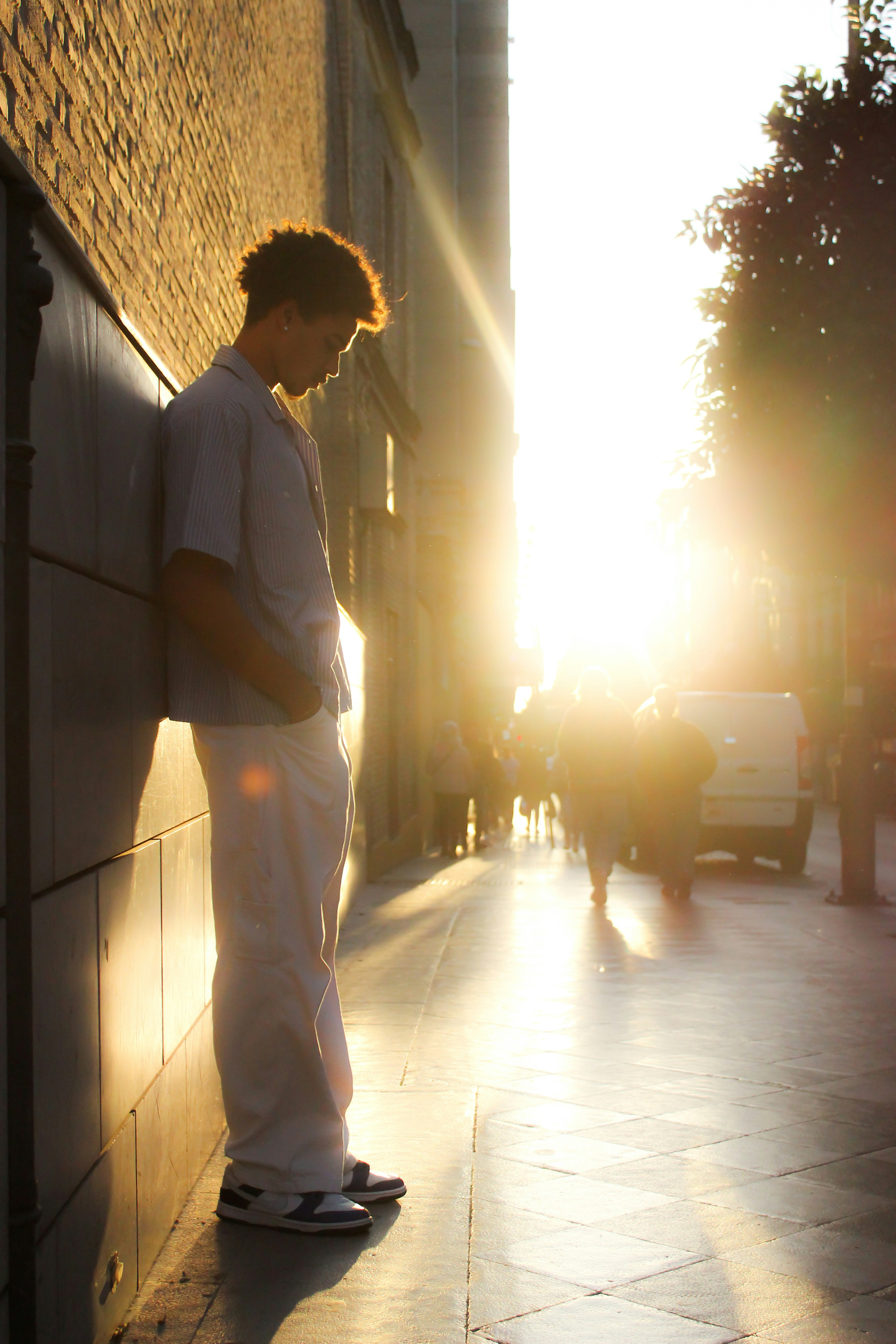 Young man leaning against wall in bright sunlight photo – Free Image on ...