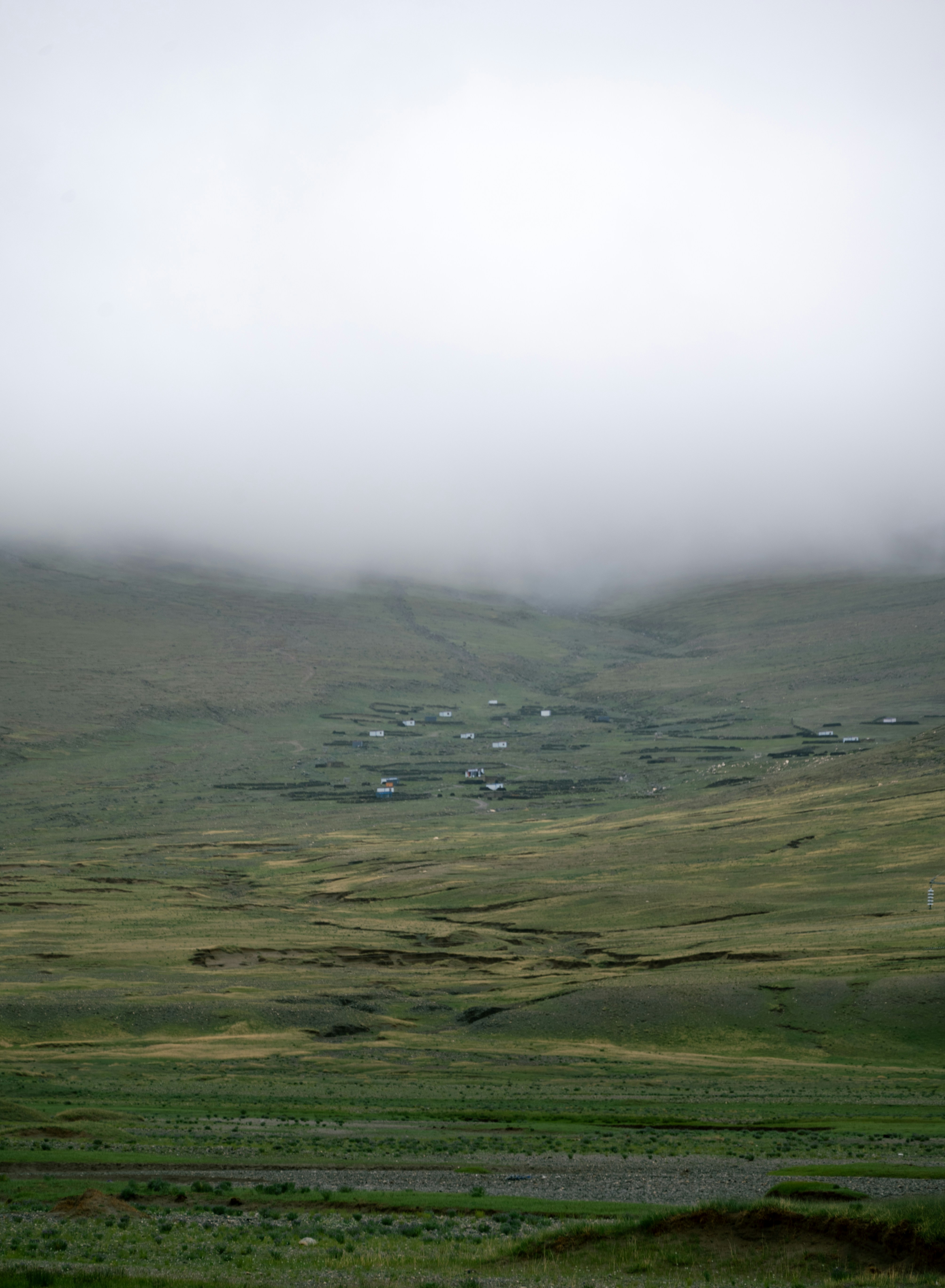 Small village nestled in a misty, green valley.