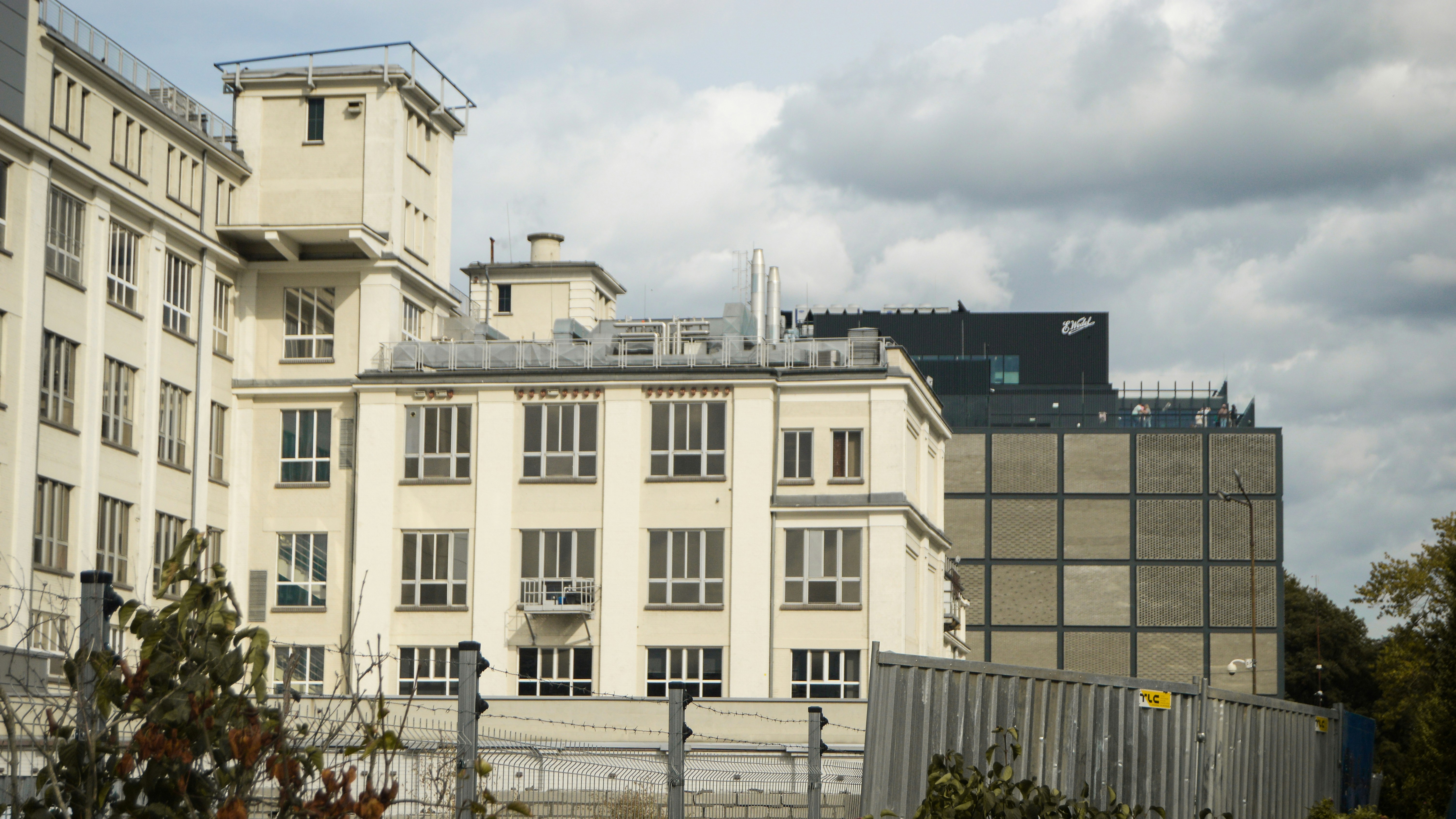 Modern building with a tower against cloudy sky