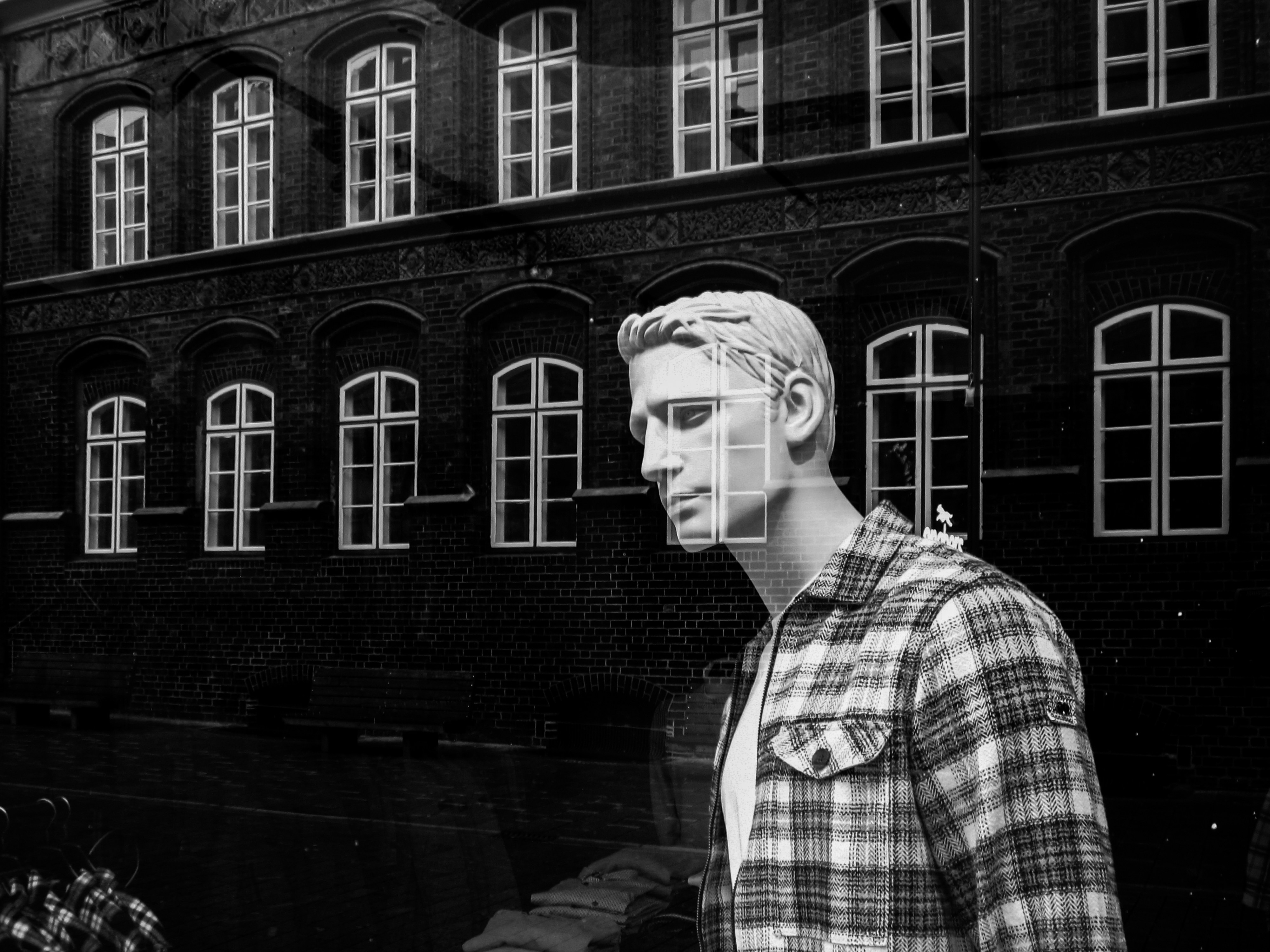 Urban reflection of a mannequin in Lübeck – street photography with a surreal twist.