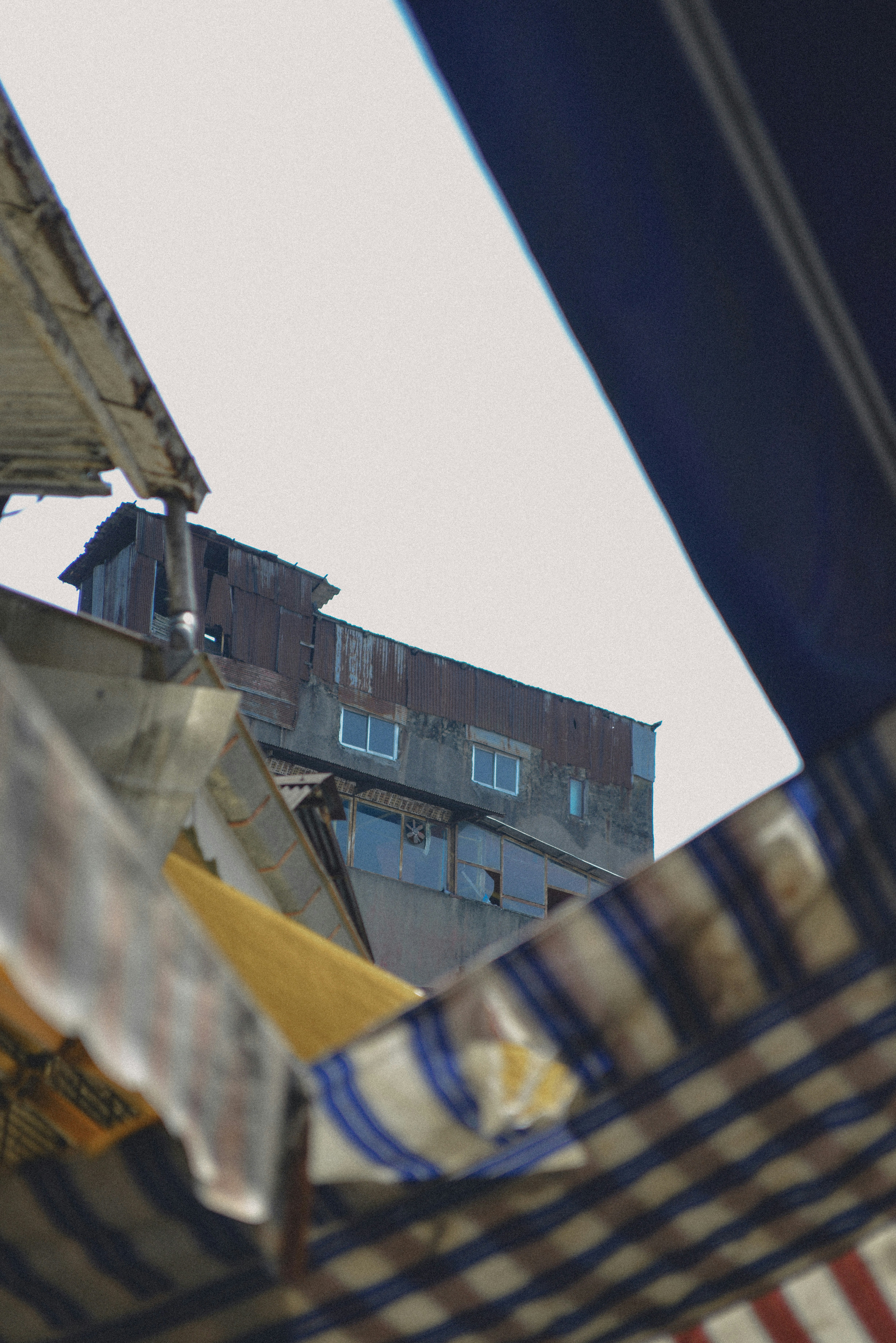 Rasht, June 2025. | Rusted corrugated iron building with white windows.