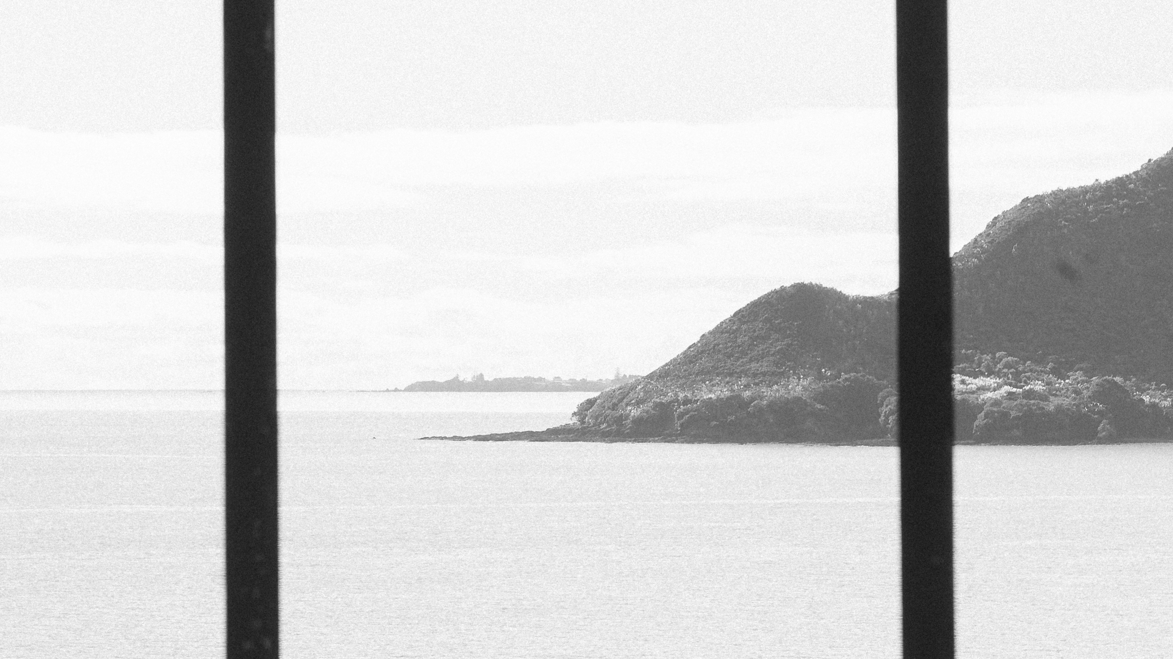 Framed Serenity: A Coastal View Through Iron Bars