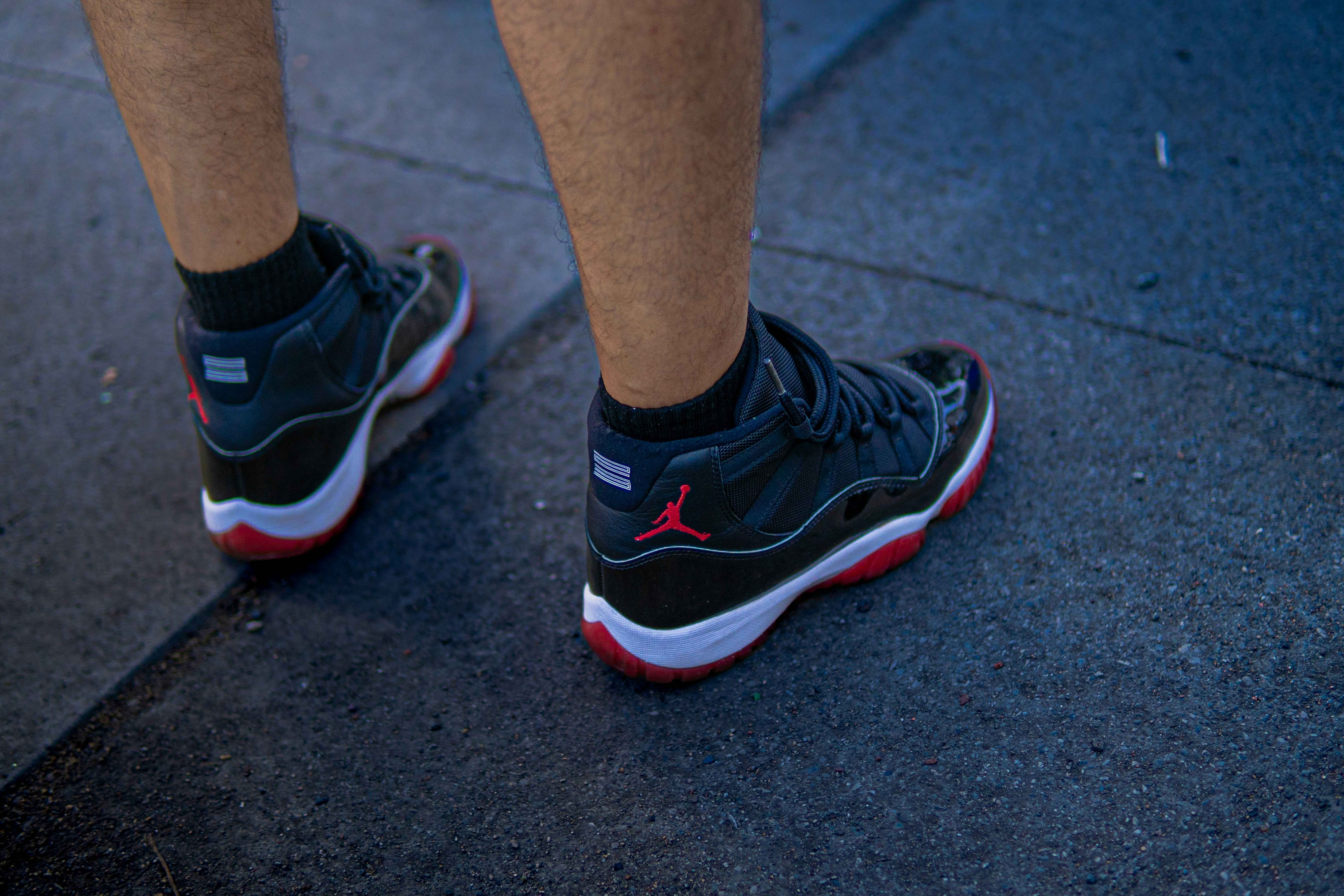 Navy Air Jordan Sneakers on Damp Asphalt: Red Jumpman in Focus