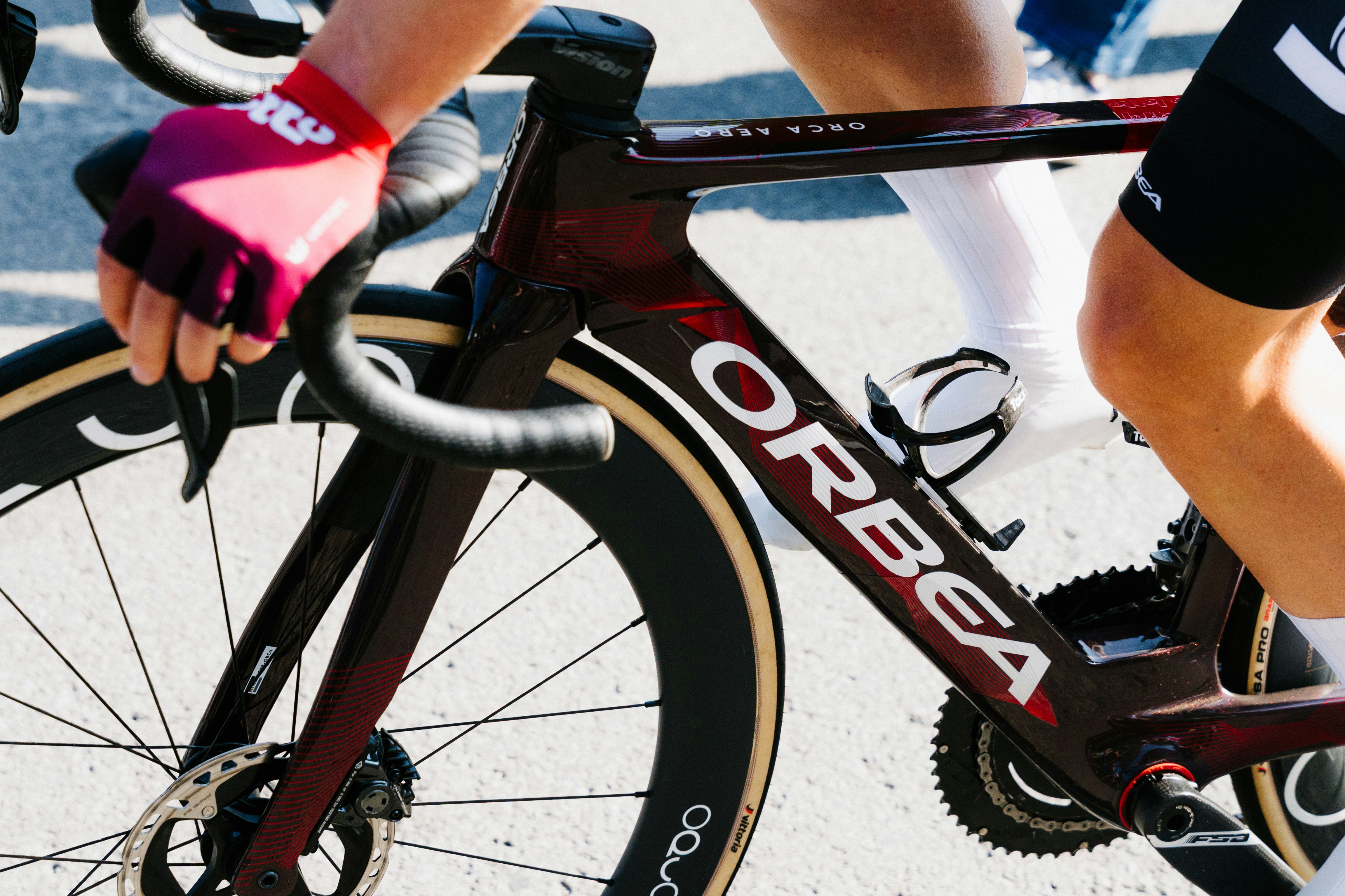Orbea in Focus: a close-up of carbon road bike, rider's grip and bold branding