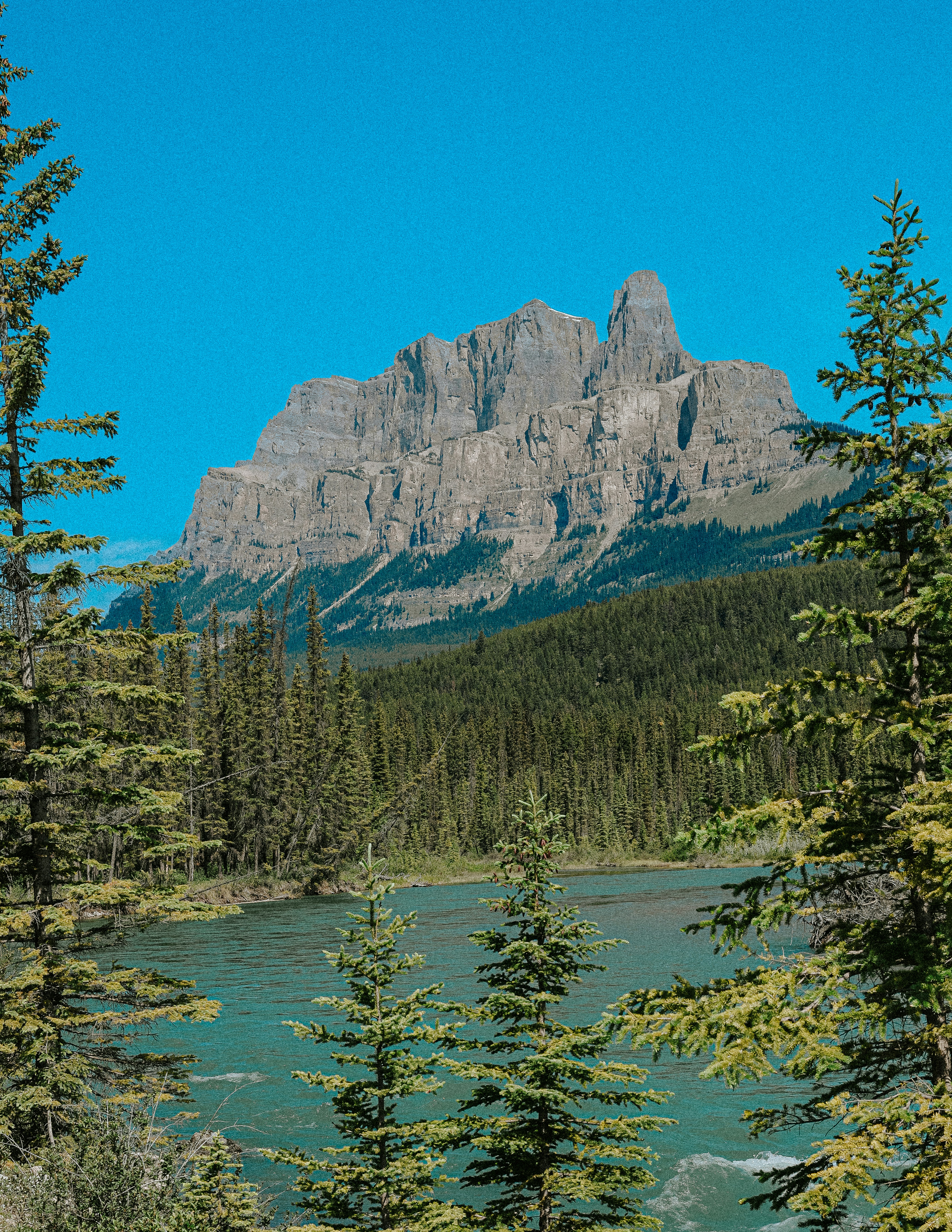 Majestic mountain range overlooks a serene turquoise lake.