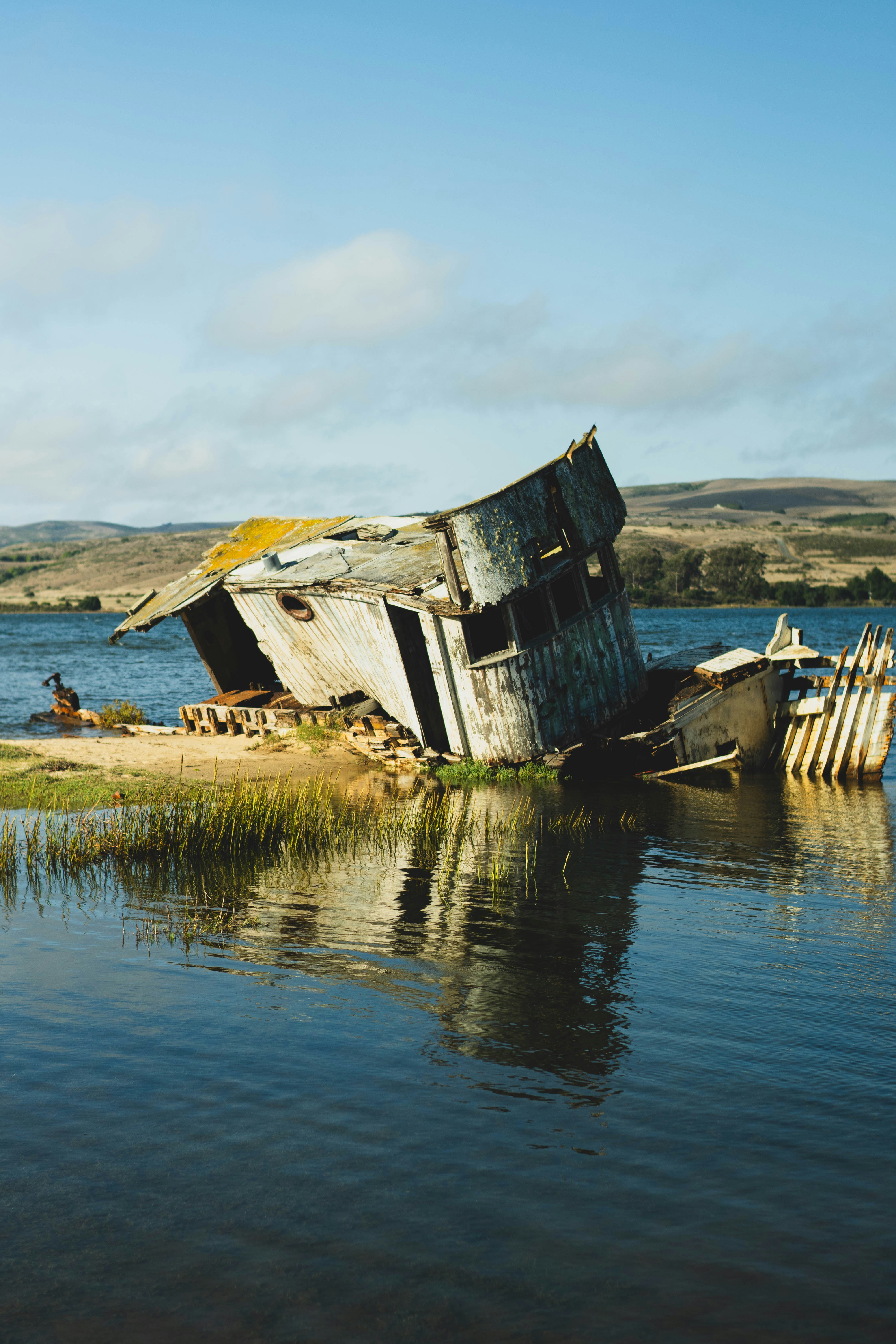 Tilted Hull at the Lagoon: Weathered Wood and Quiet Reflections