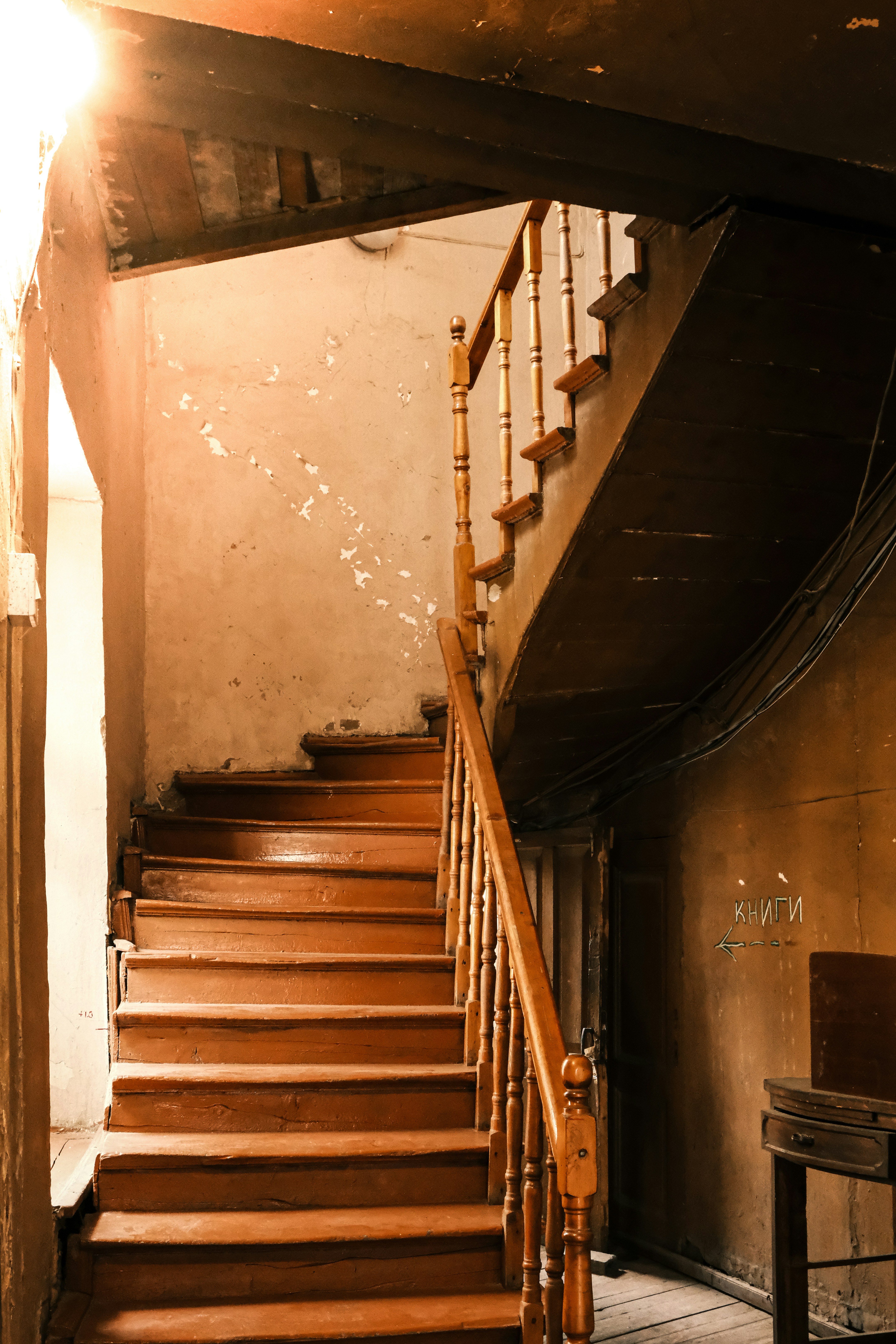 Wooden staircase in an old building with sunlight