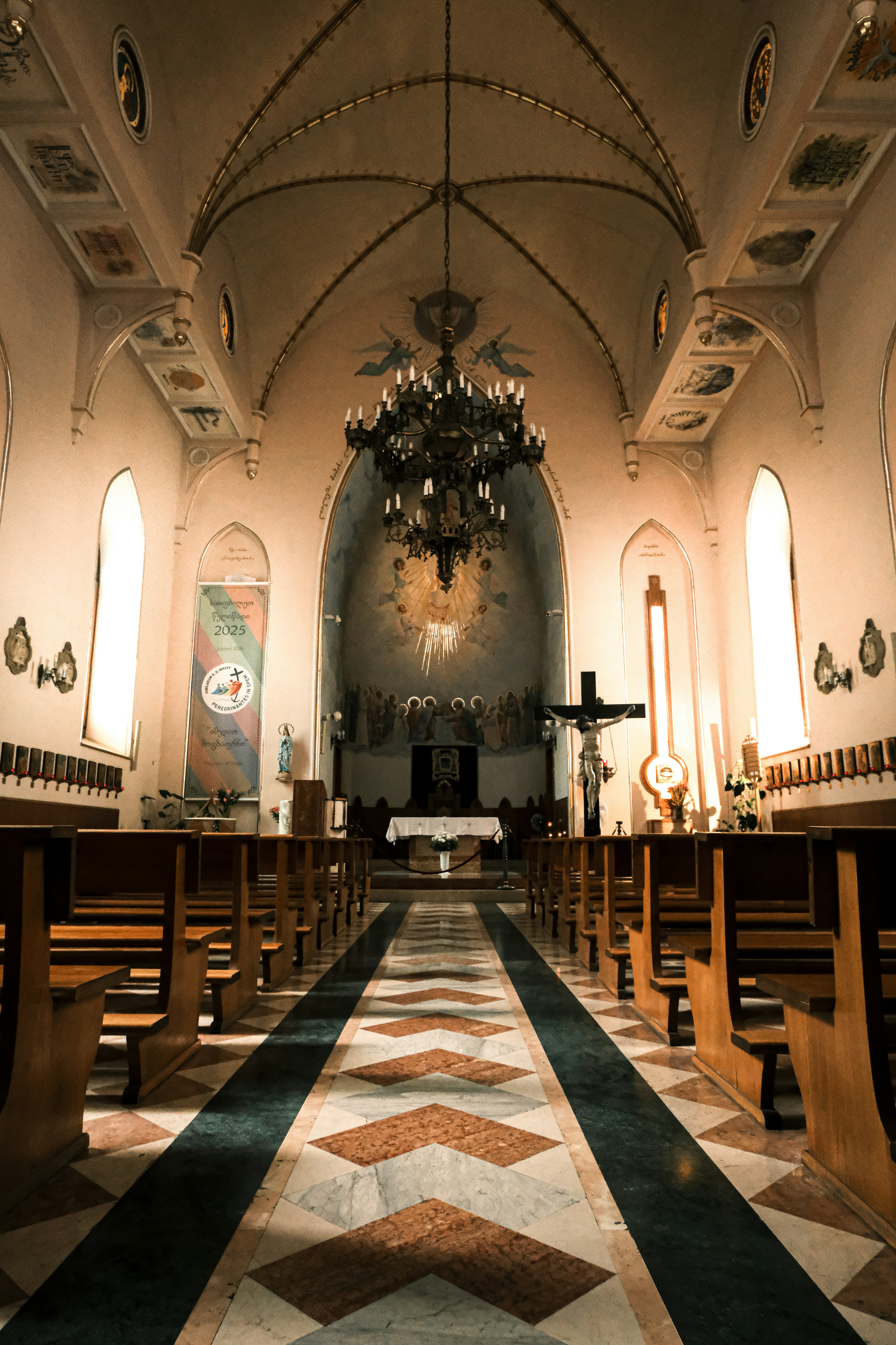Interior of a beautifully designed church showcasing wooden pews and a striking altar under an ornate ceiling.
