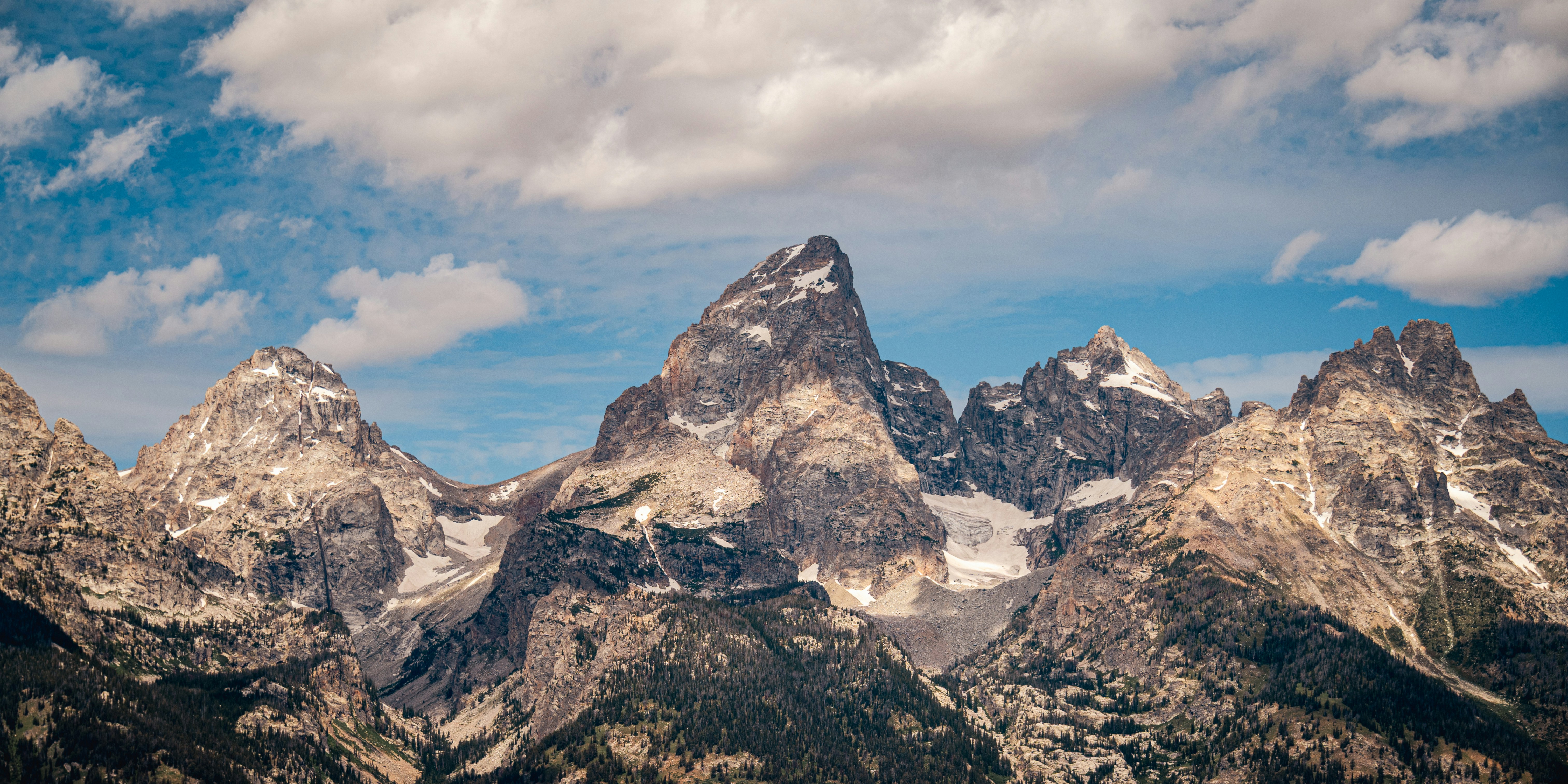 Jagged mountain peaks under a cloudy blue sky.