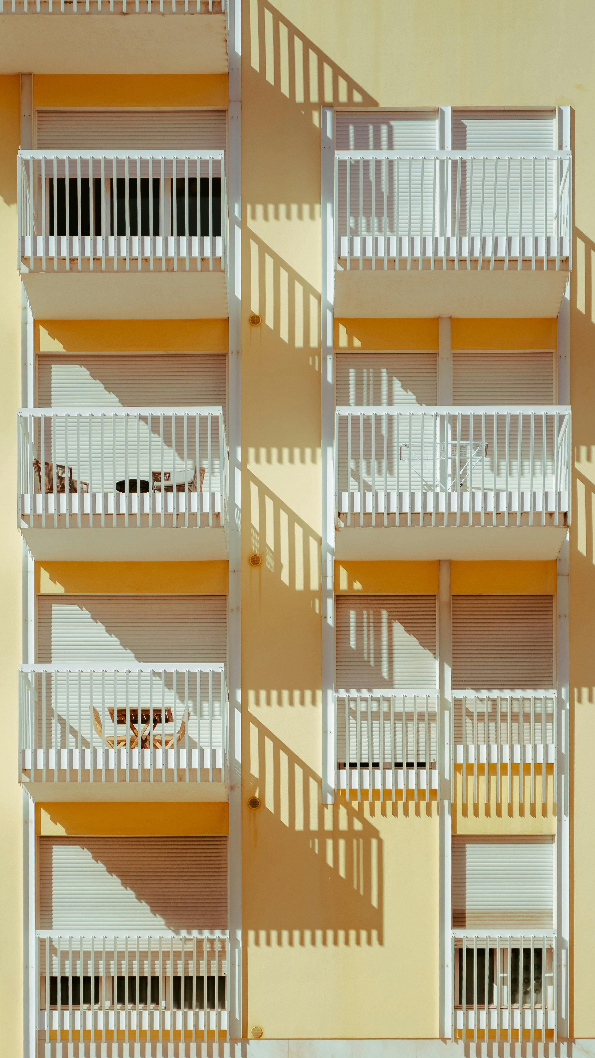 Building balconies with strong shadows cast by railings. photo – Free ...