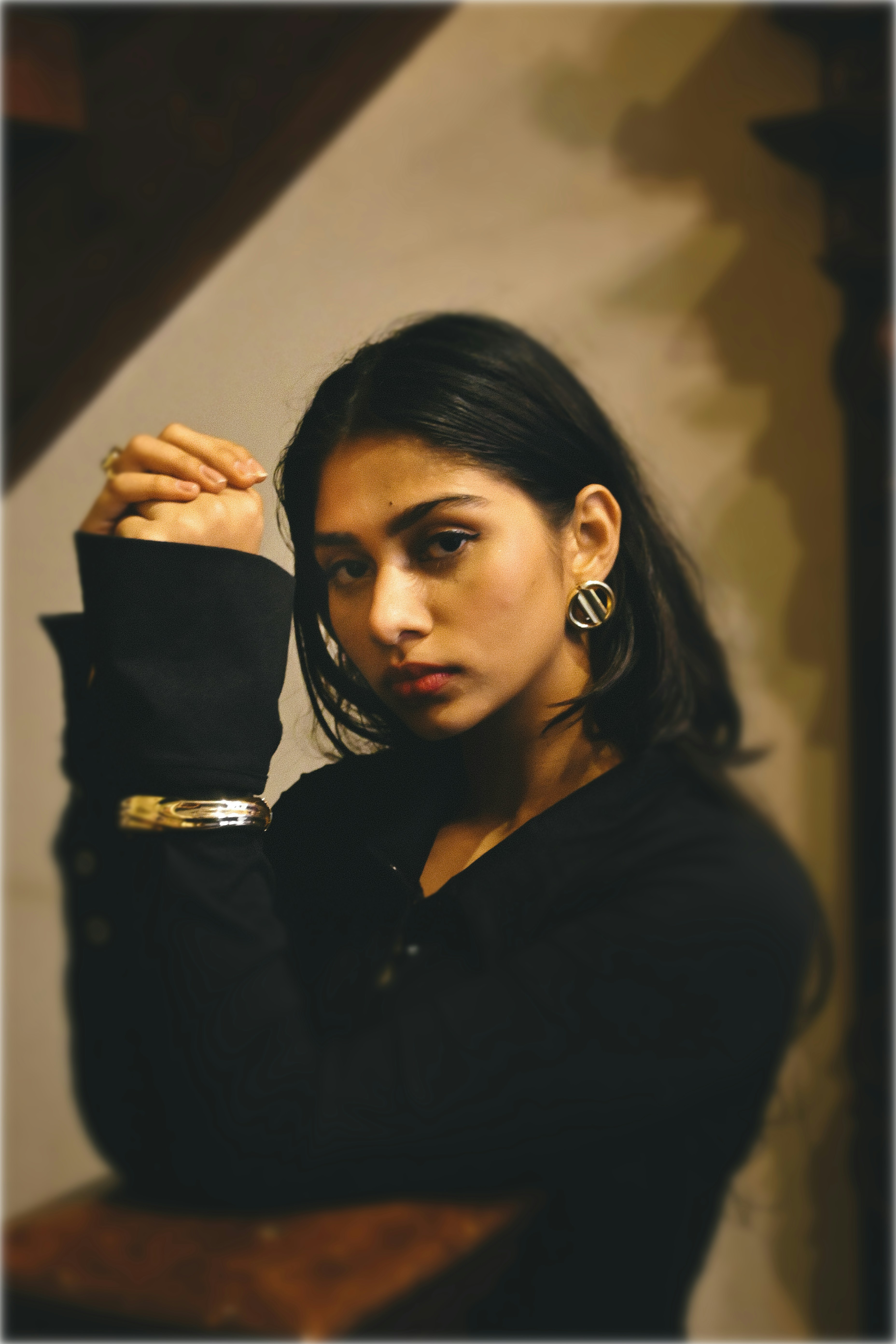 A young woman with dark hair wearing jewelry.