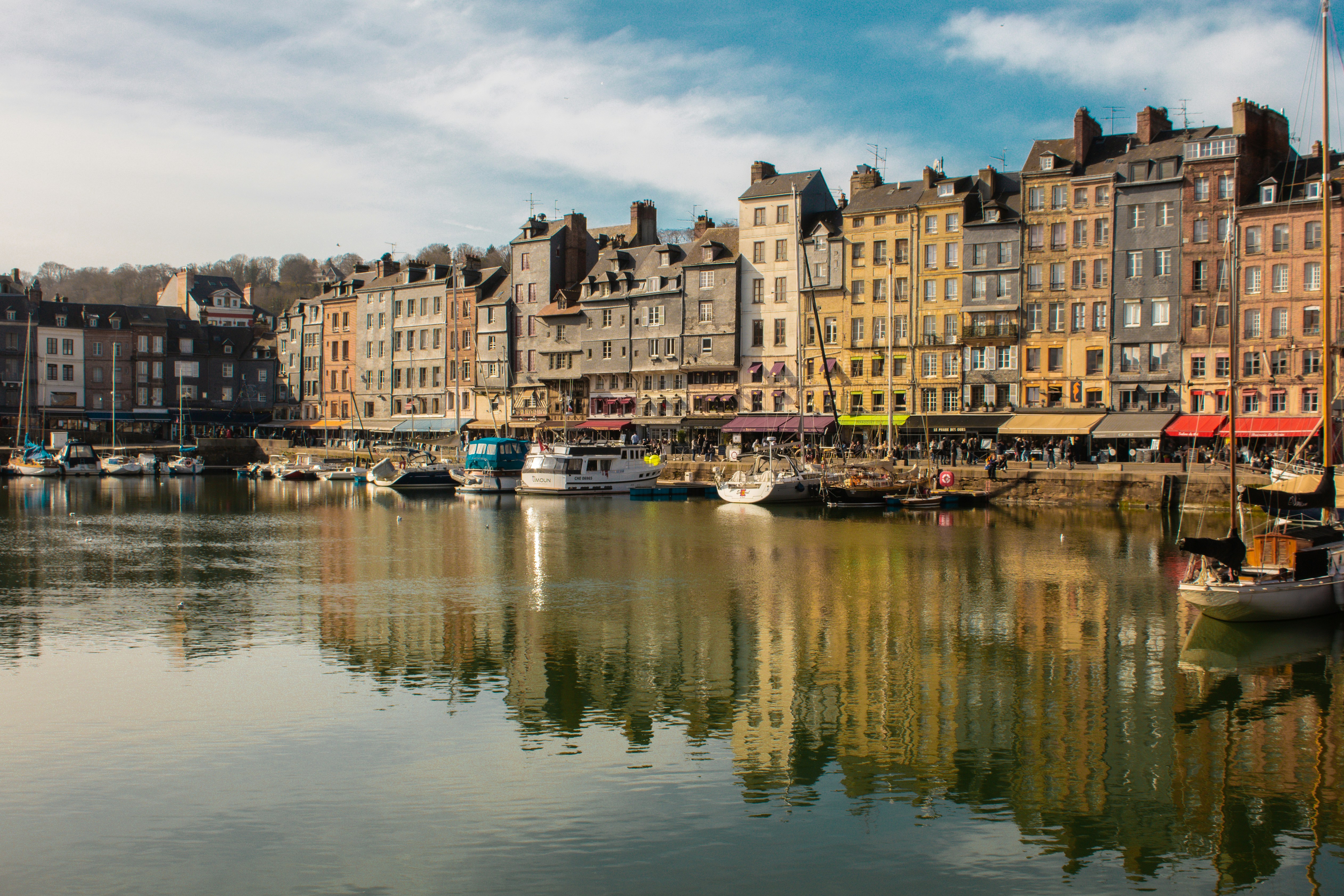Colorful historic buildings line a harbor with boats.