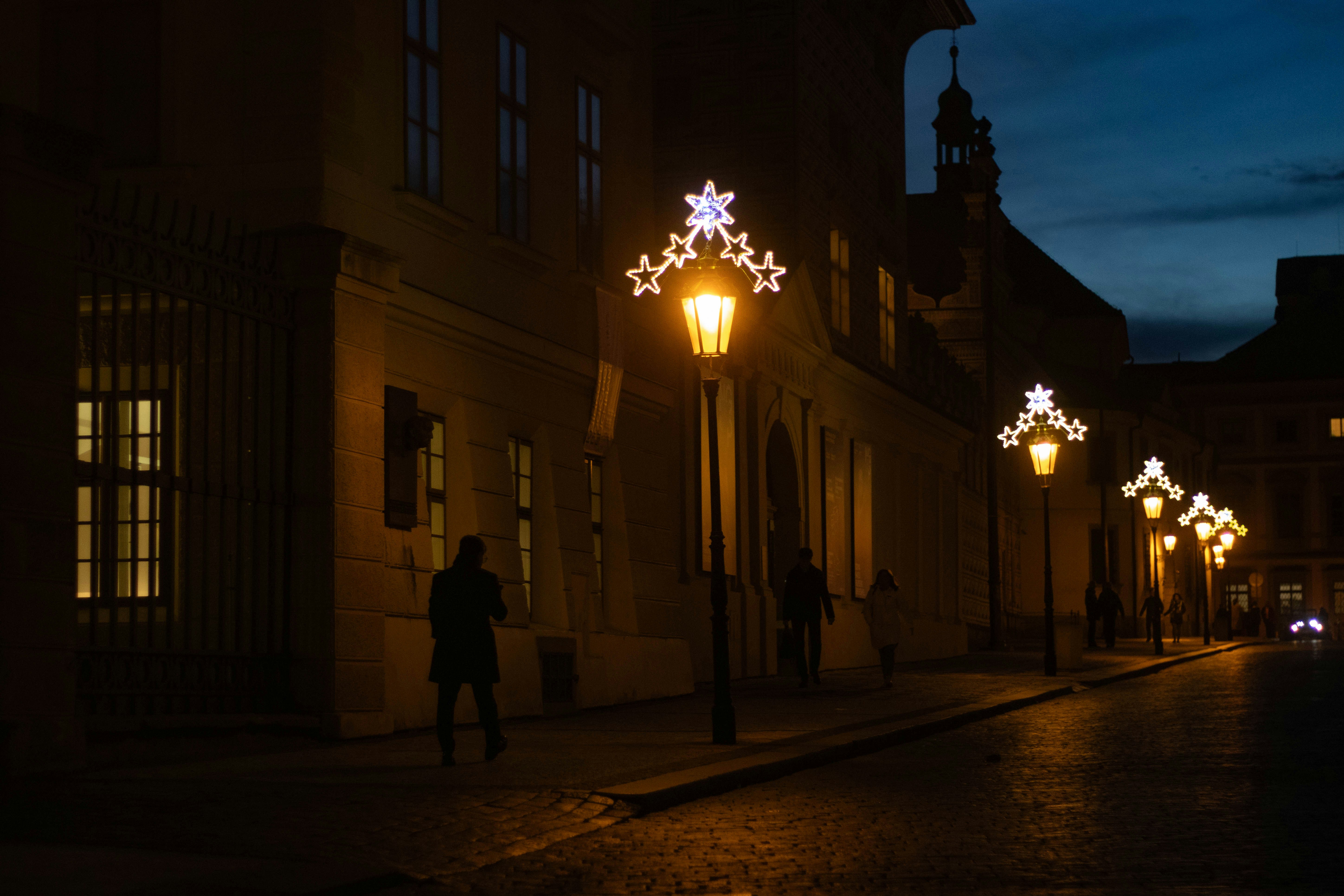 Night Lanterns and Star Ornaments Along a Quiet Cobblestone Street