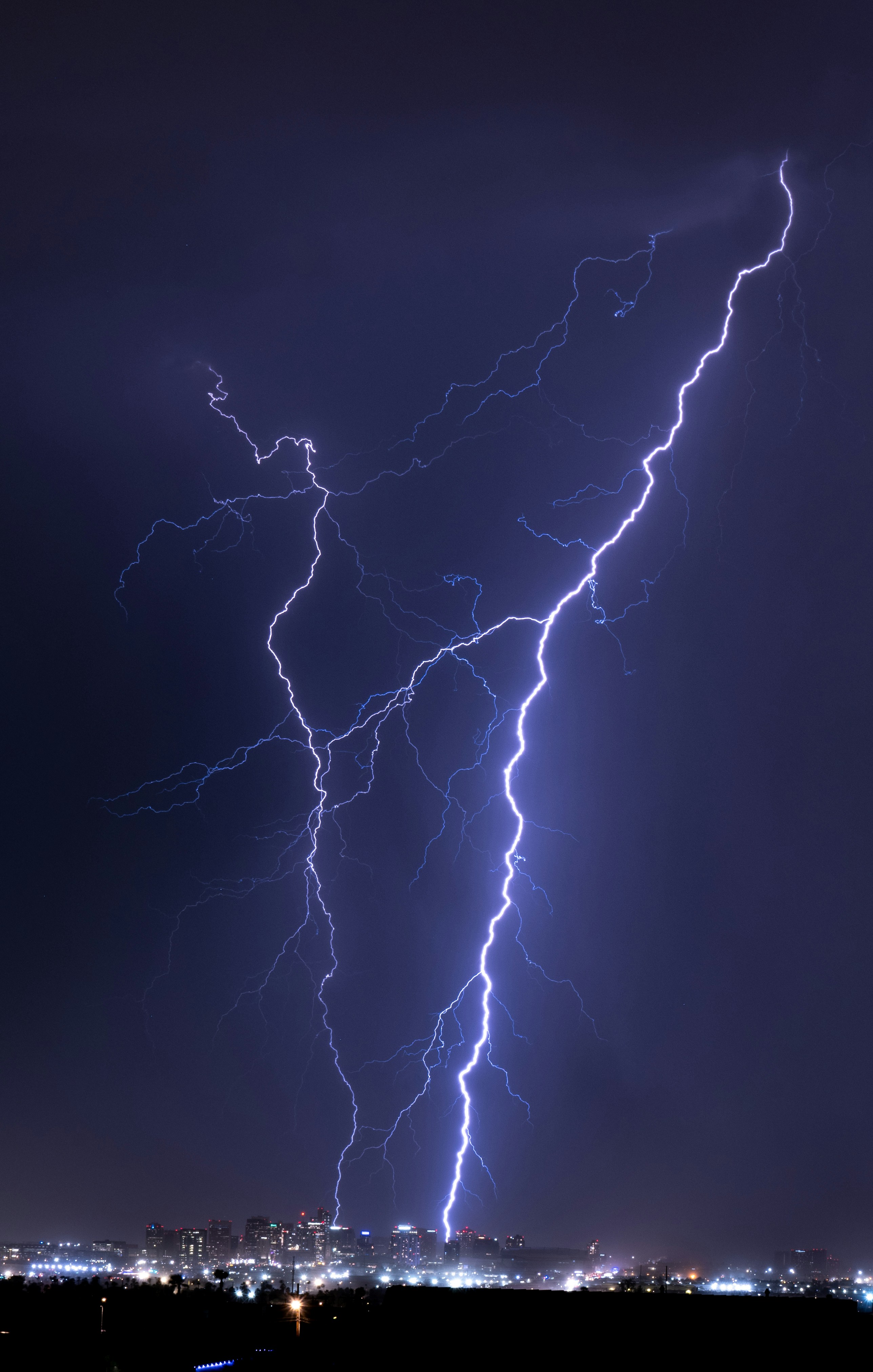 Lightning strikes illuminate a city skyline at night. photo – Free Usa ...