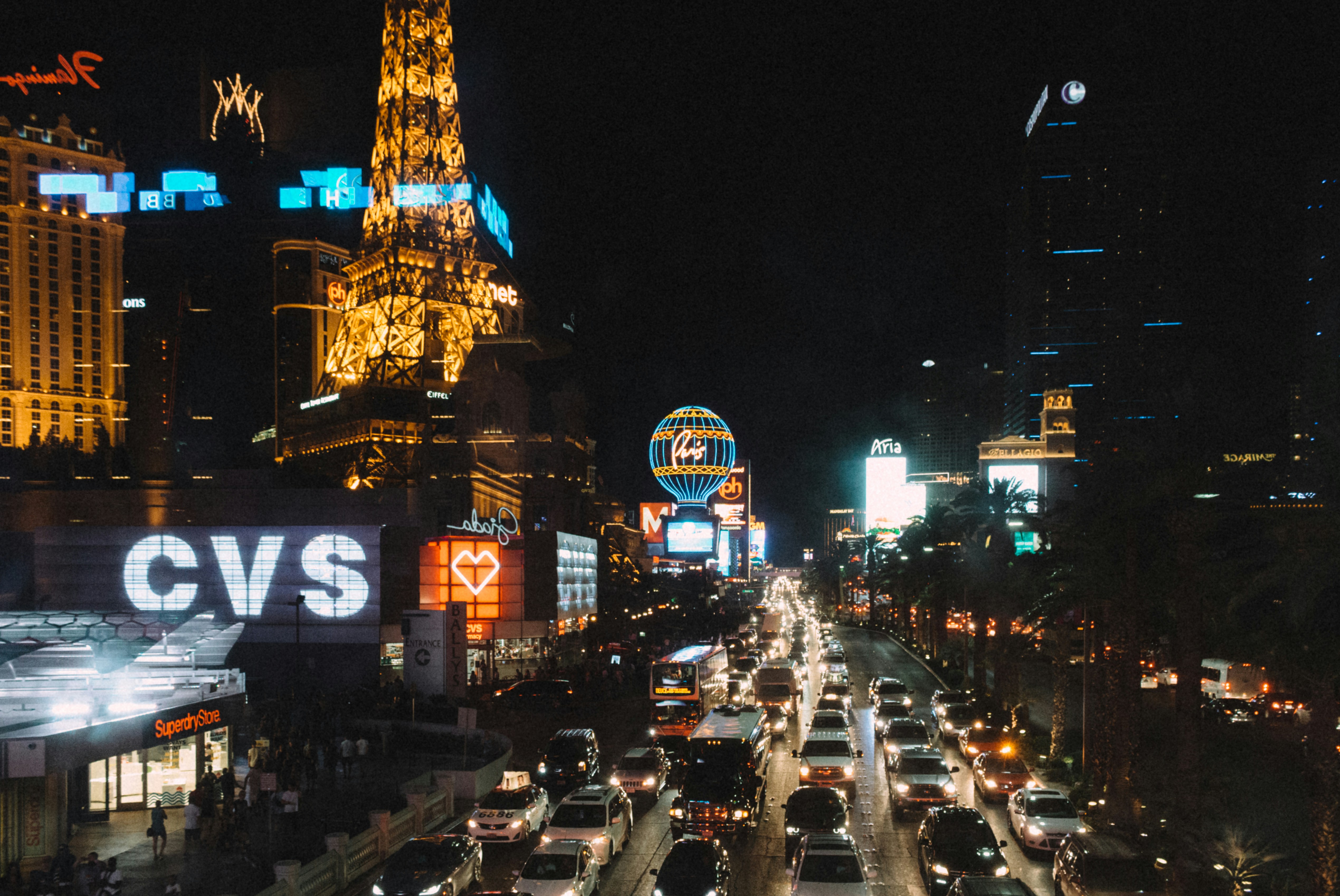 Busy street with traffic and illuminated buildings at night.