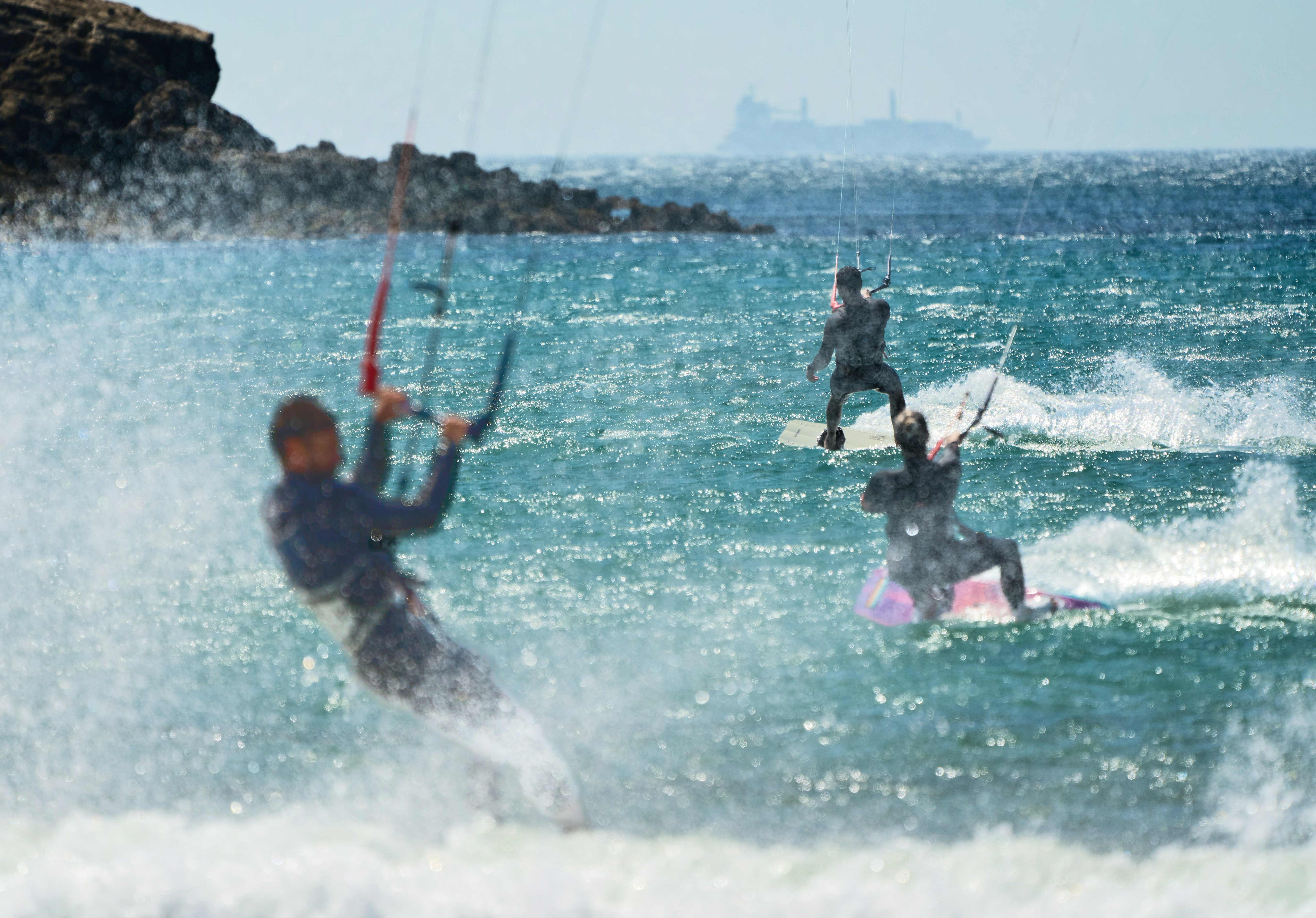 Kite surfers riding waves on a sunny day