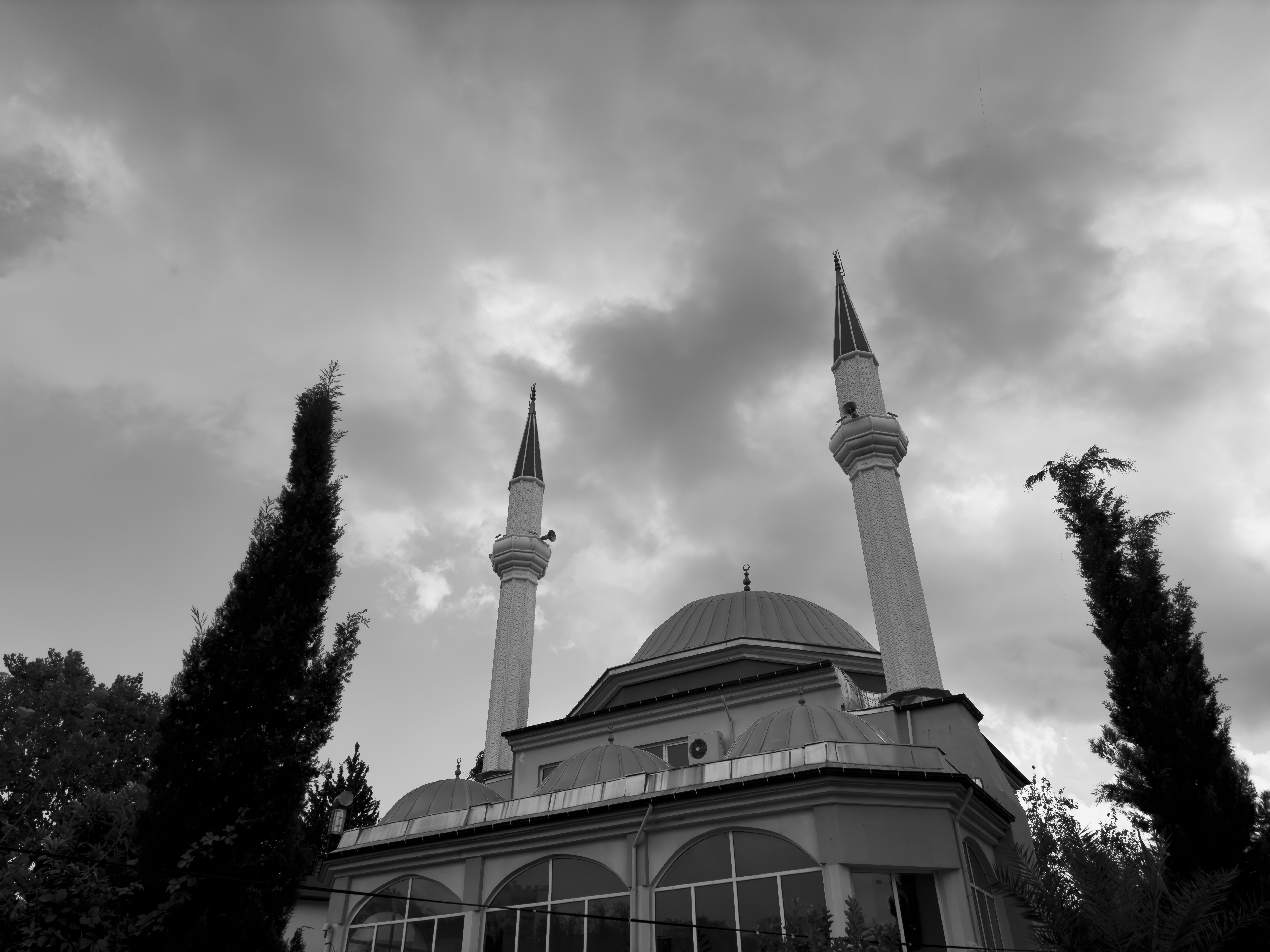 Monochrome Mosque: Twin Minarets Framing a Cloudy Sky