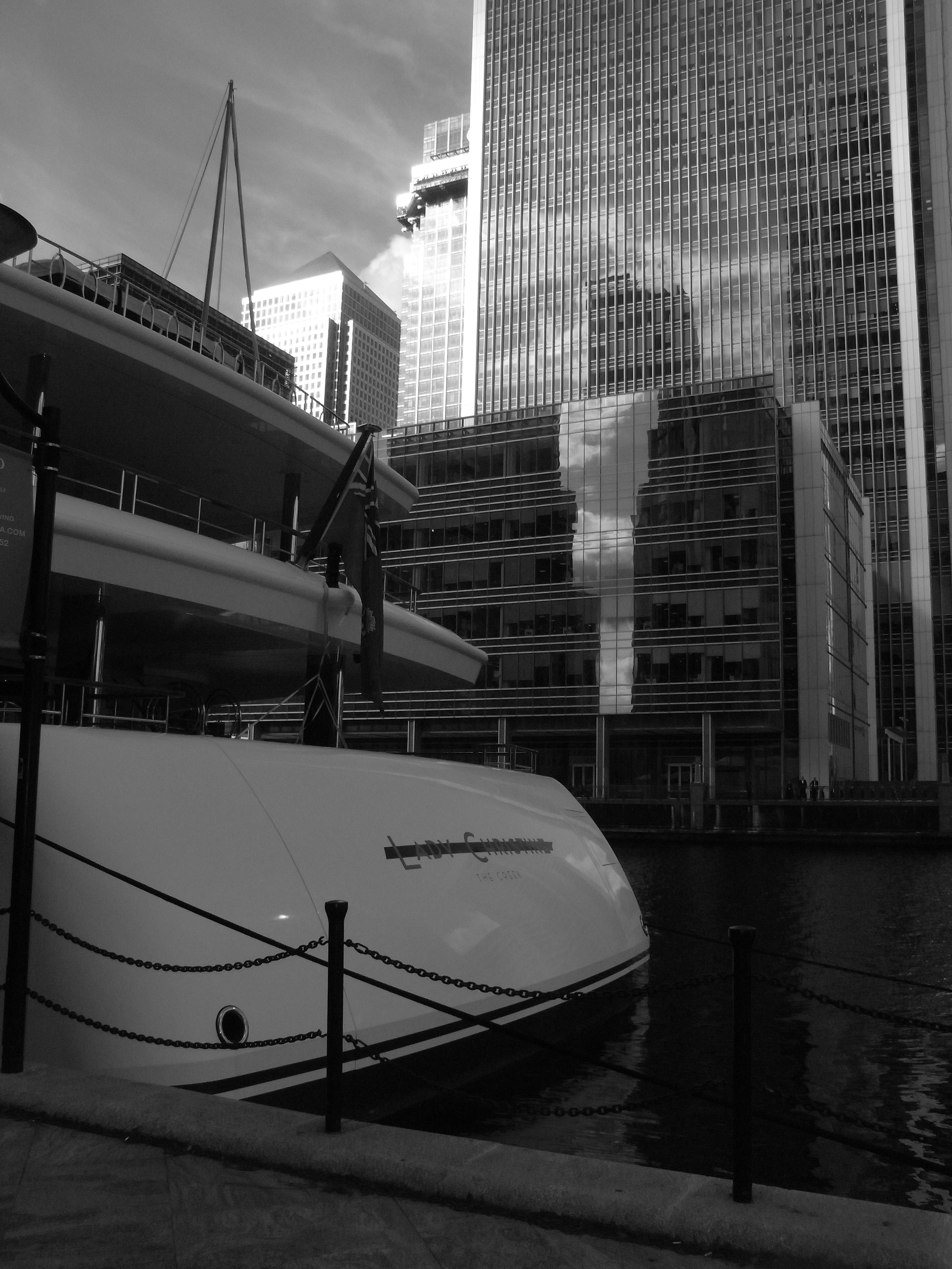 Modern yacht docked near skyscrapers in city