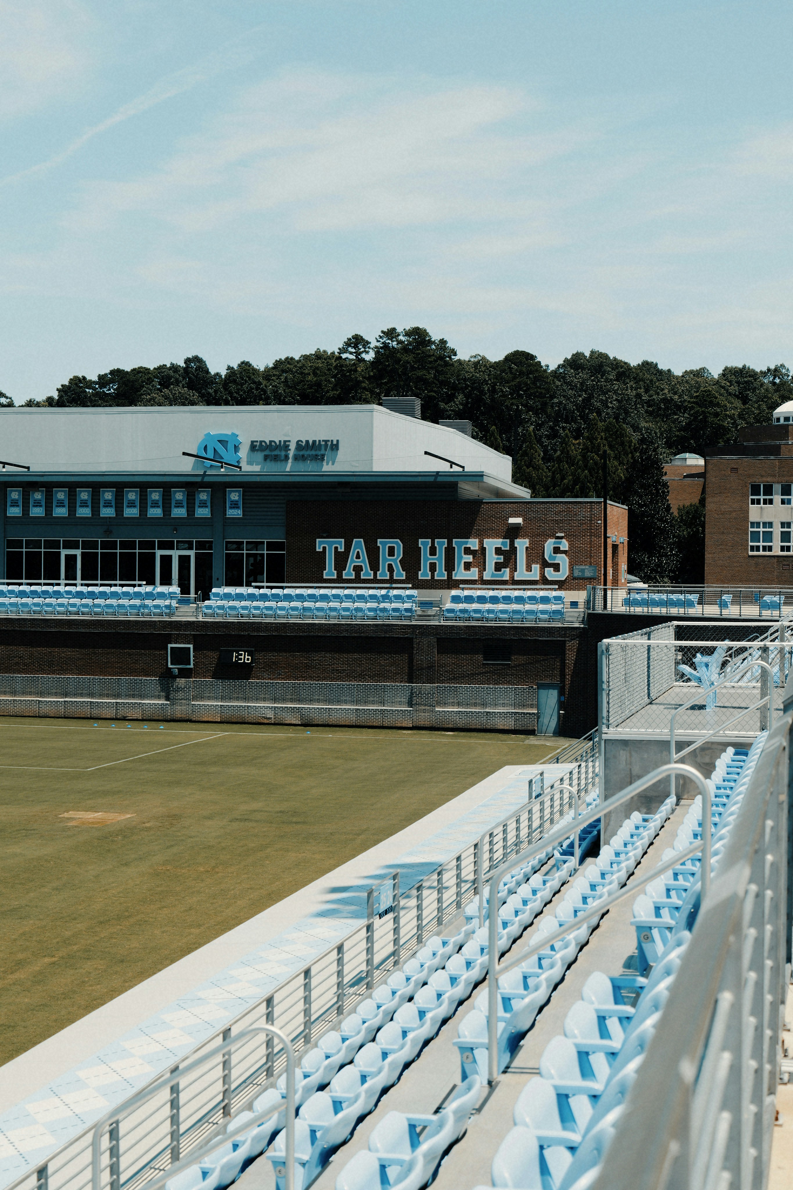 Tar Heels Stand: Quiet Symmetry of Blue Seats and Brick Facade