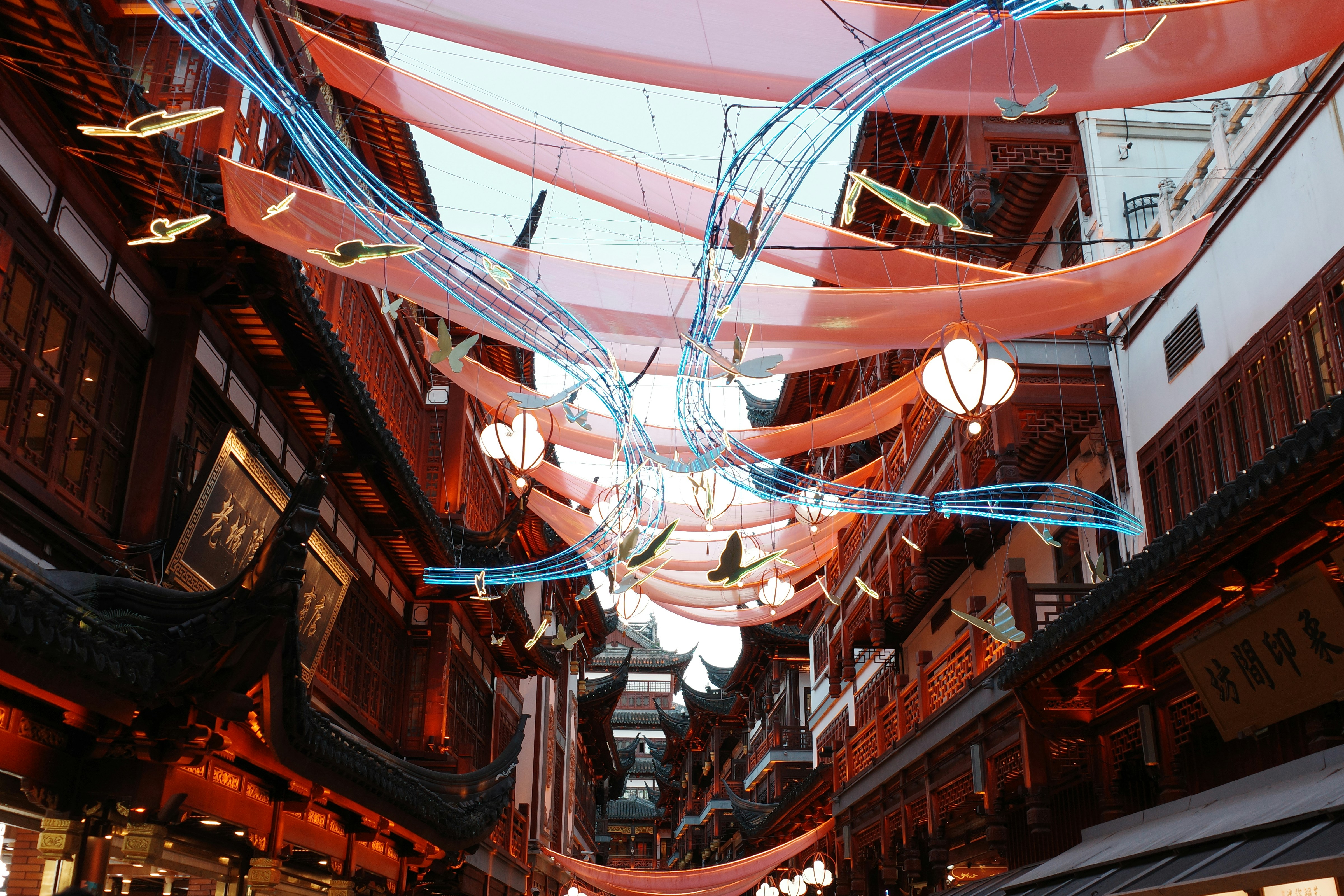 Colorful decorations hang above traditional asian market stalls.