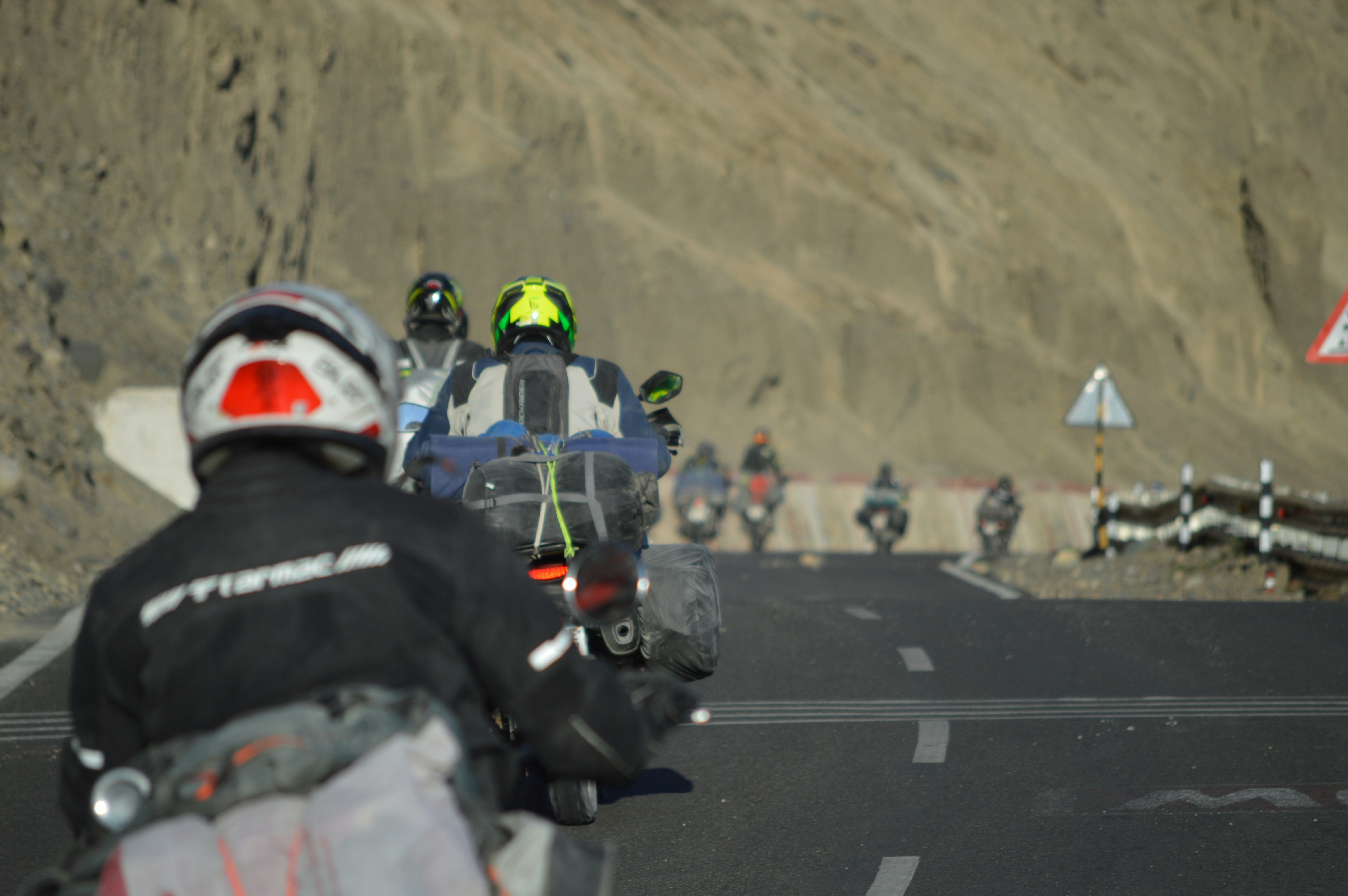 Motorcyclists navigating a winding road through a rugged landscape, showcasing the spirit of exploration and camaraderie.