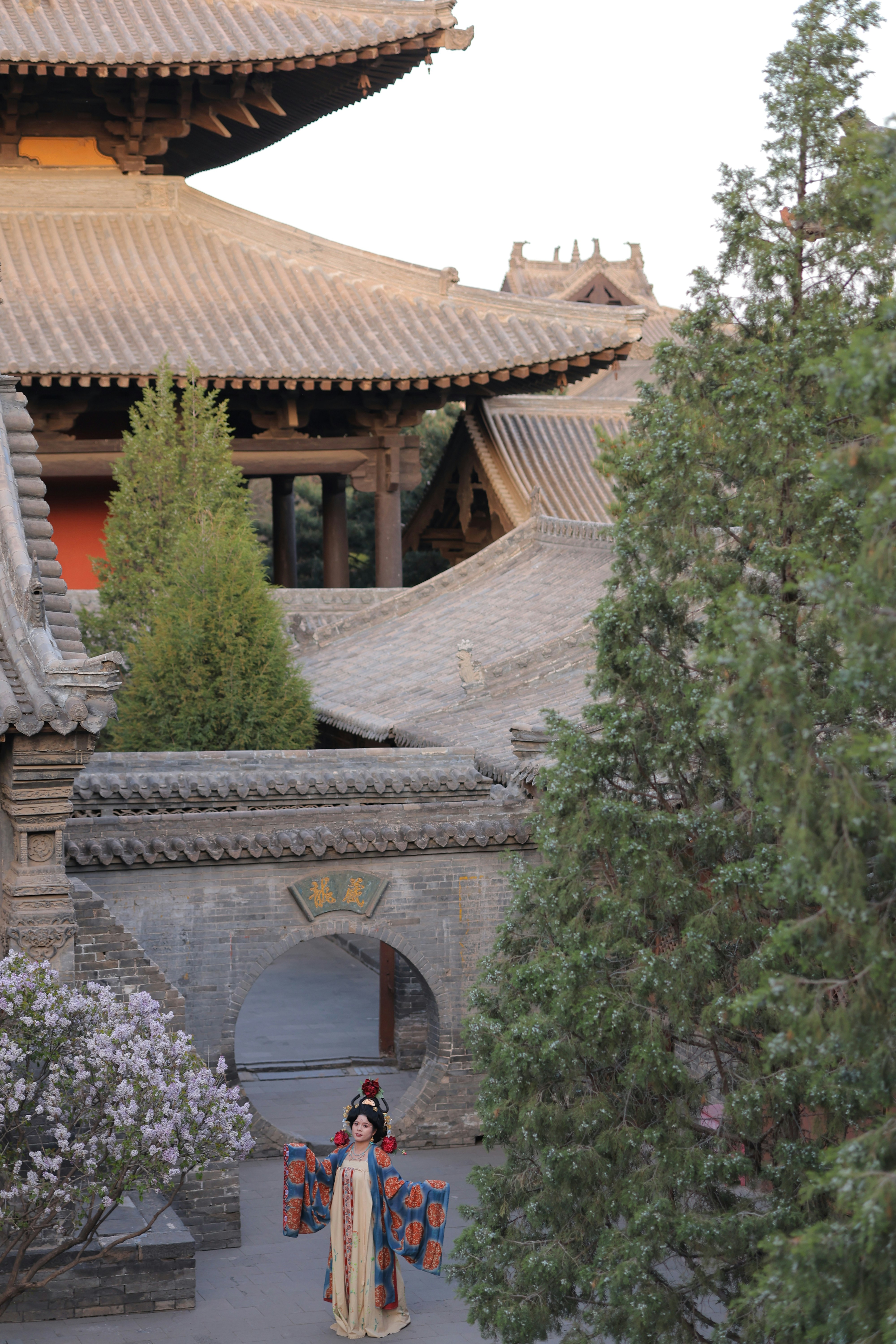 Moon Gate Portrait: Robed Figure Beneath Ancient Eaves