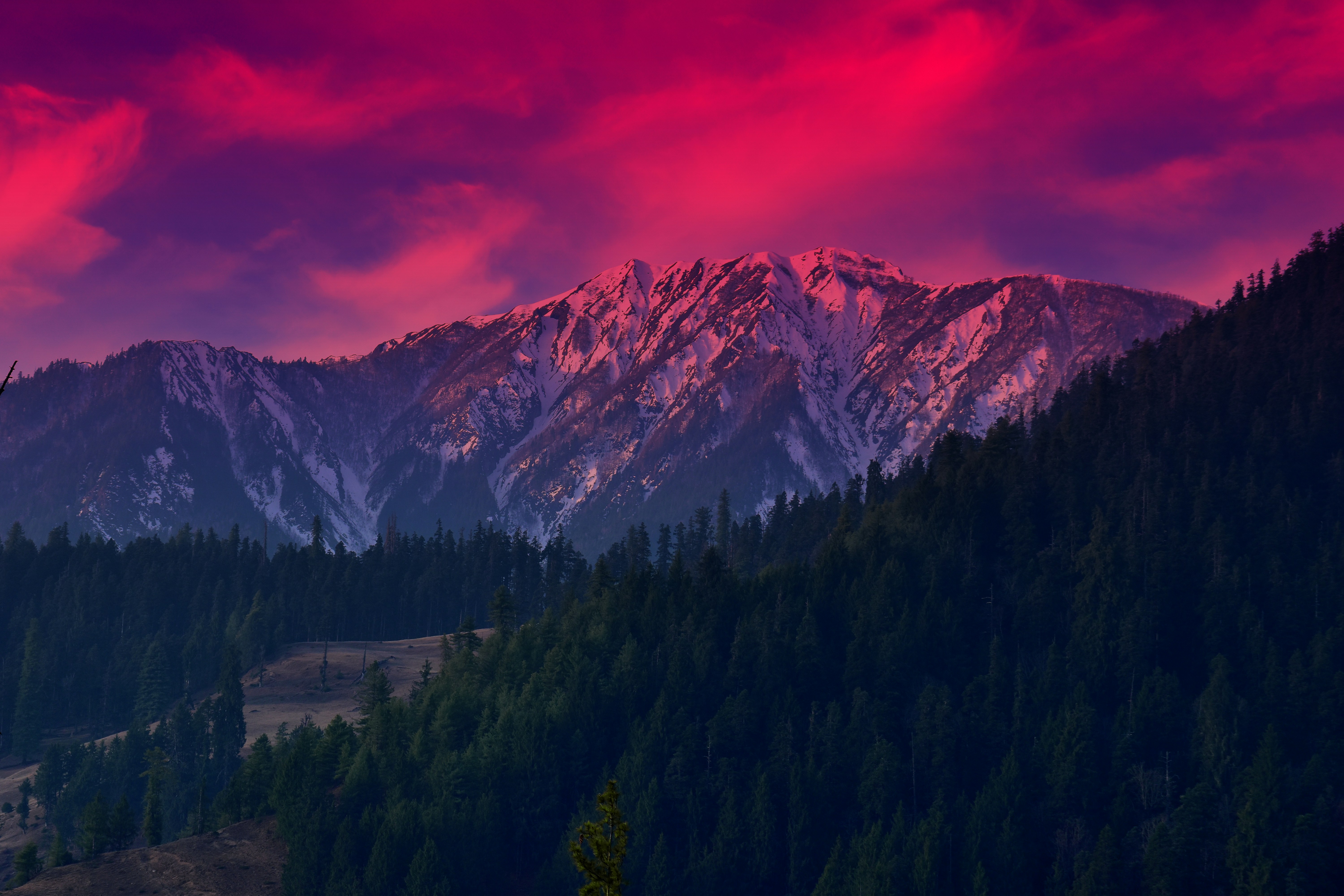We take Himalayas as Mountain Gods. | Snow-capped mountains under a vibrant pink sky