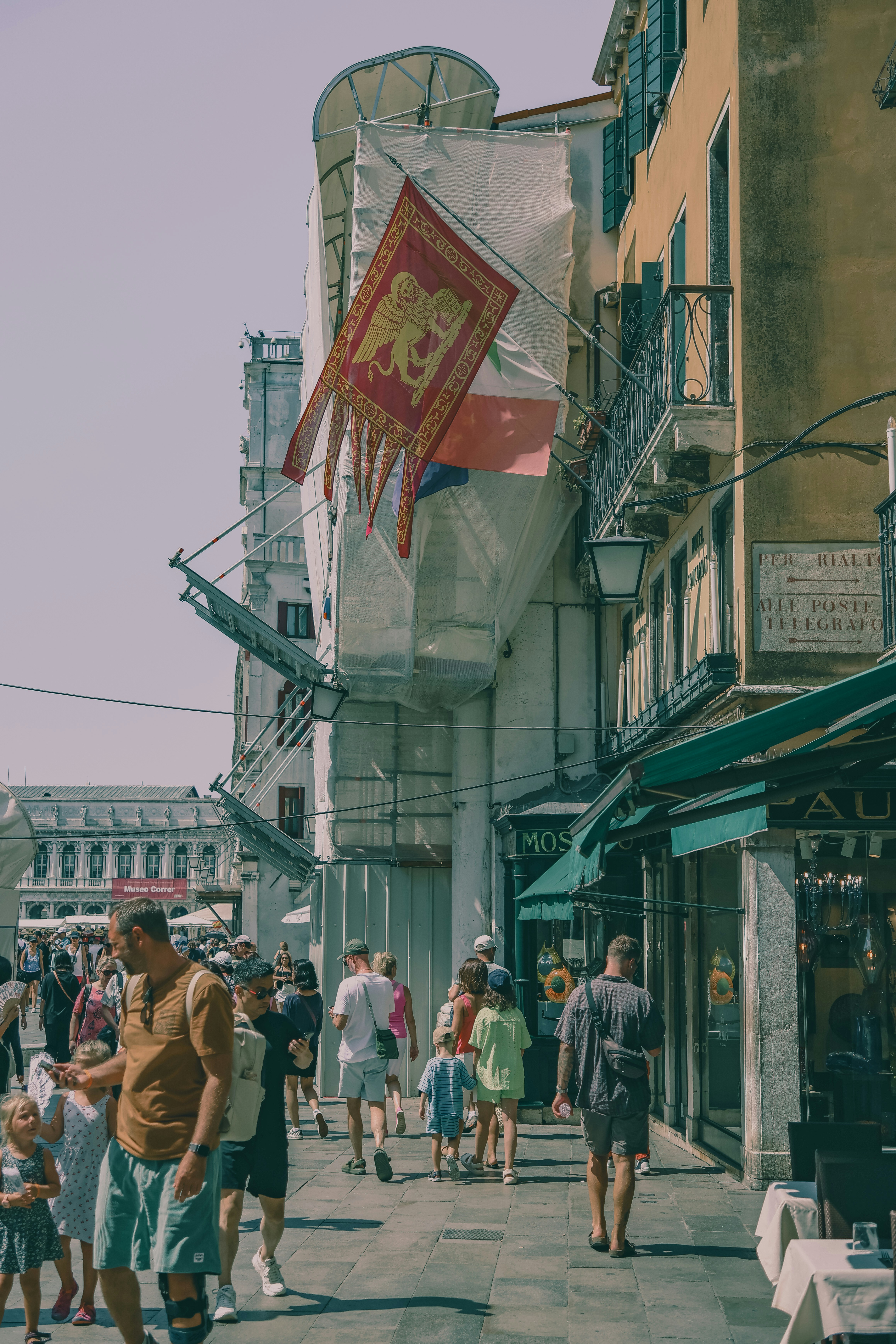 People walk along a sunny street in venice.