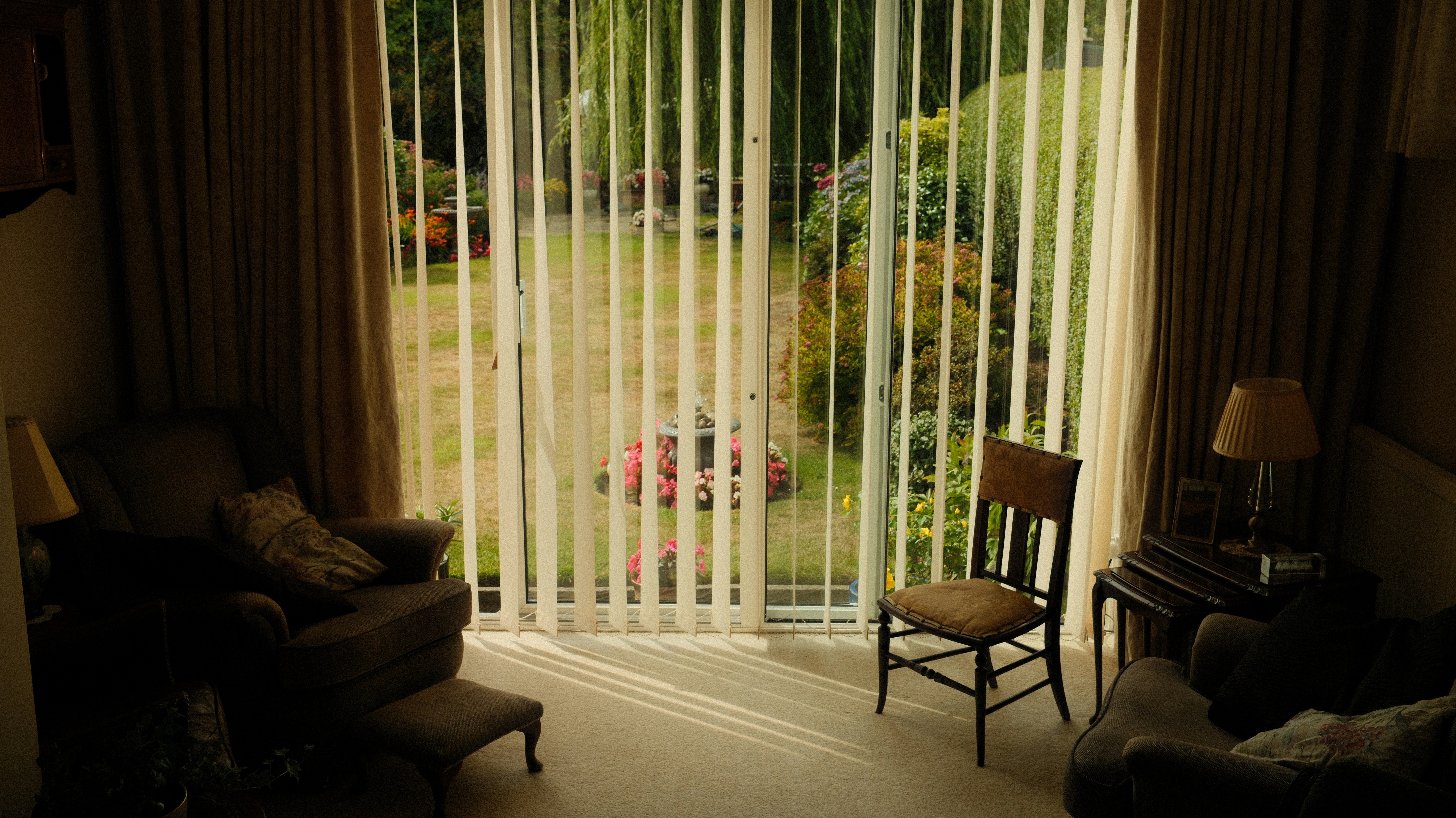 Living room with vertical blinds and garden view