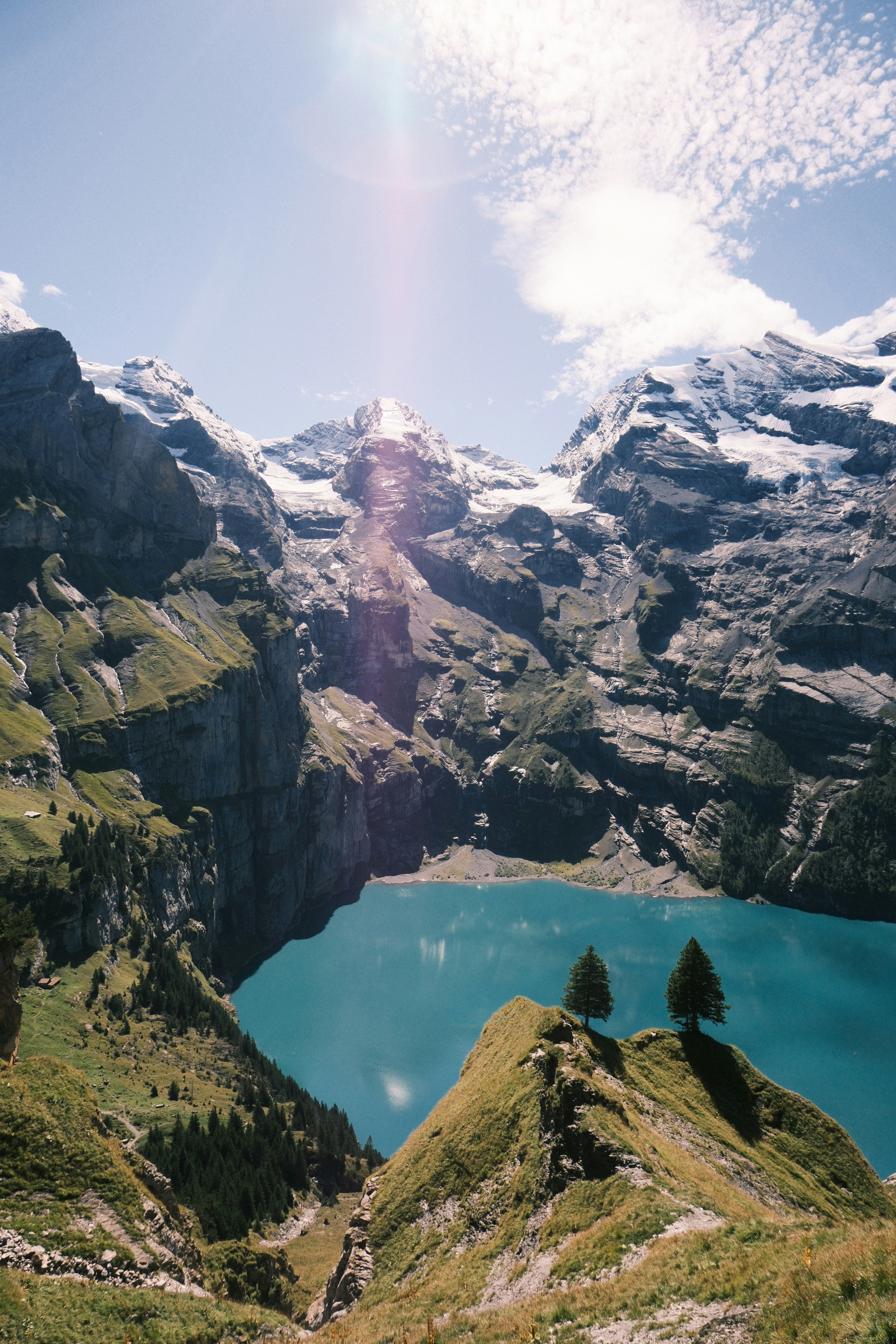 Turquoise lake surrounded by rocky, snow-capped mountains.