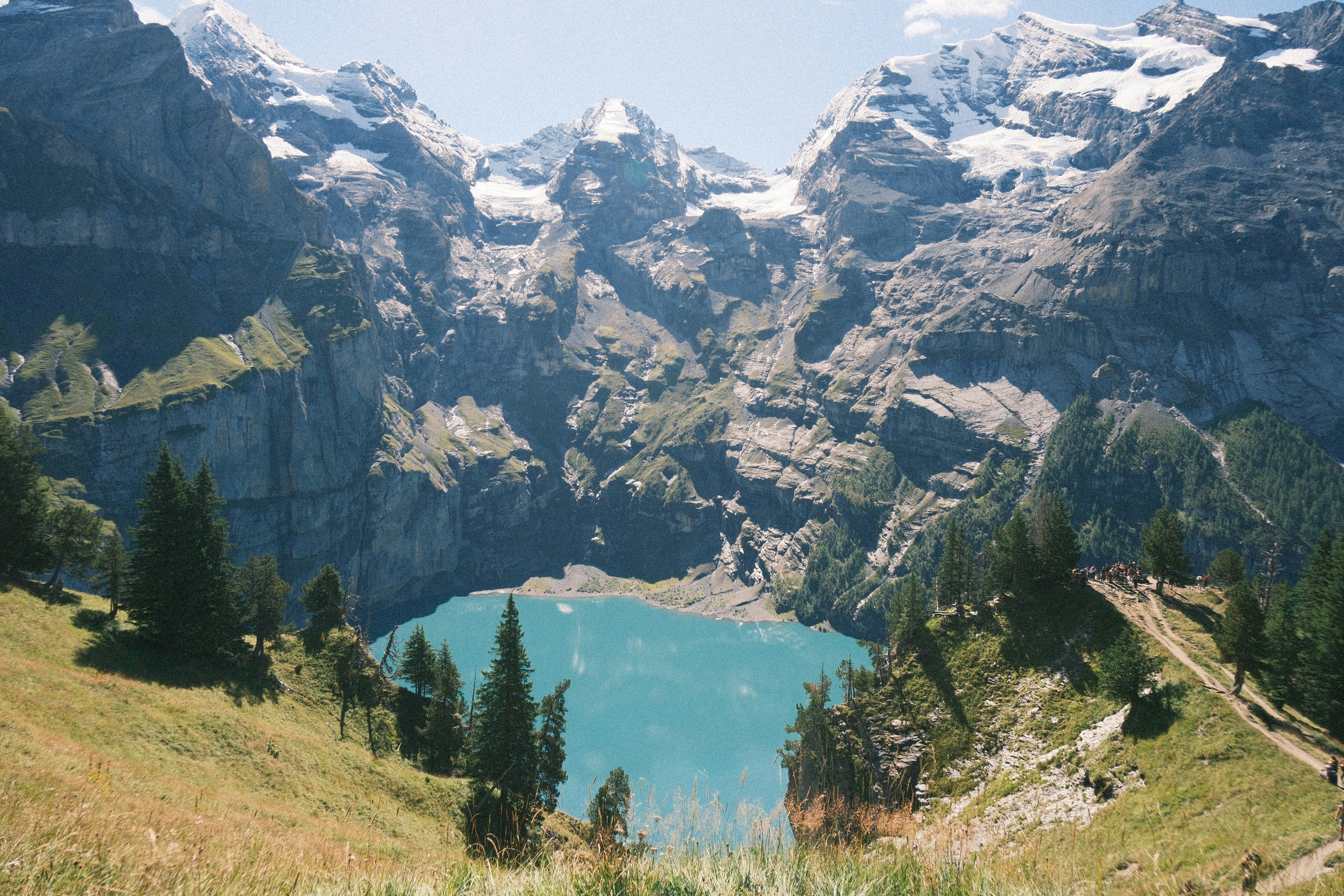 Turquoise lake surrounded by rugged mountains and green trees