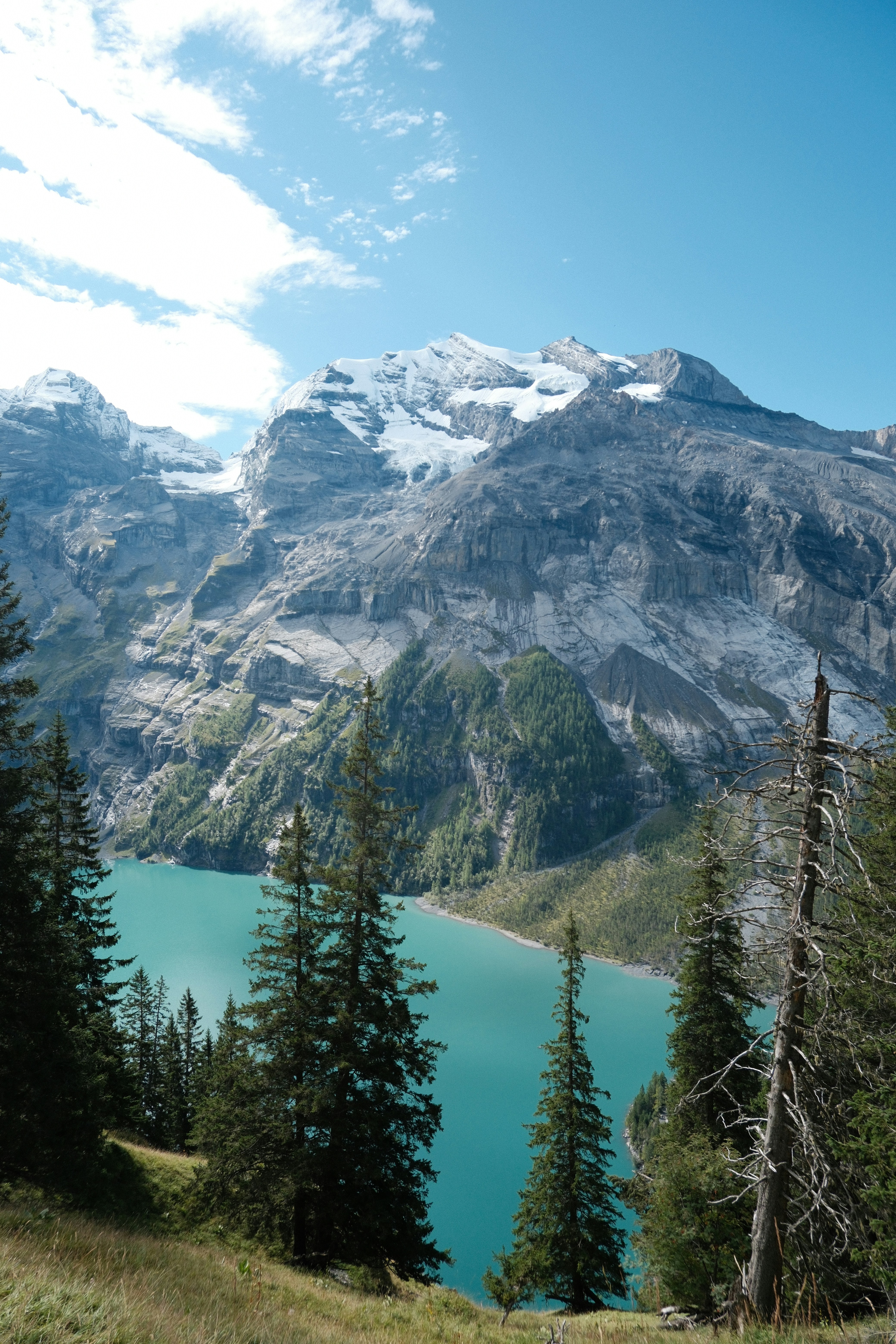 Turquoise lake surrounded by mountains and pine trees.