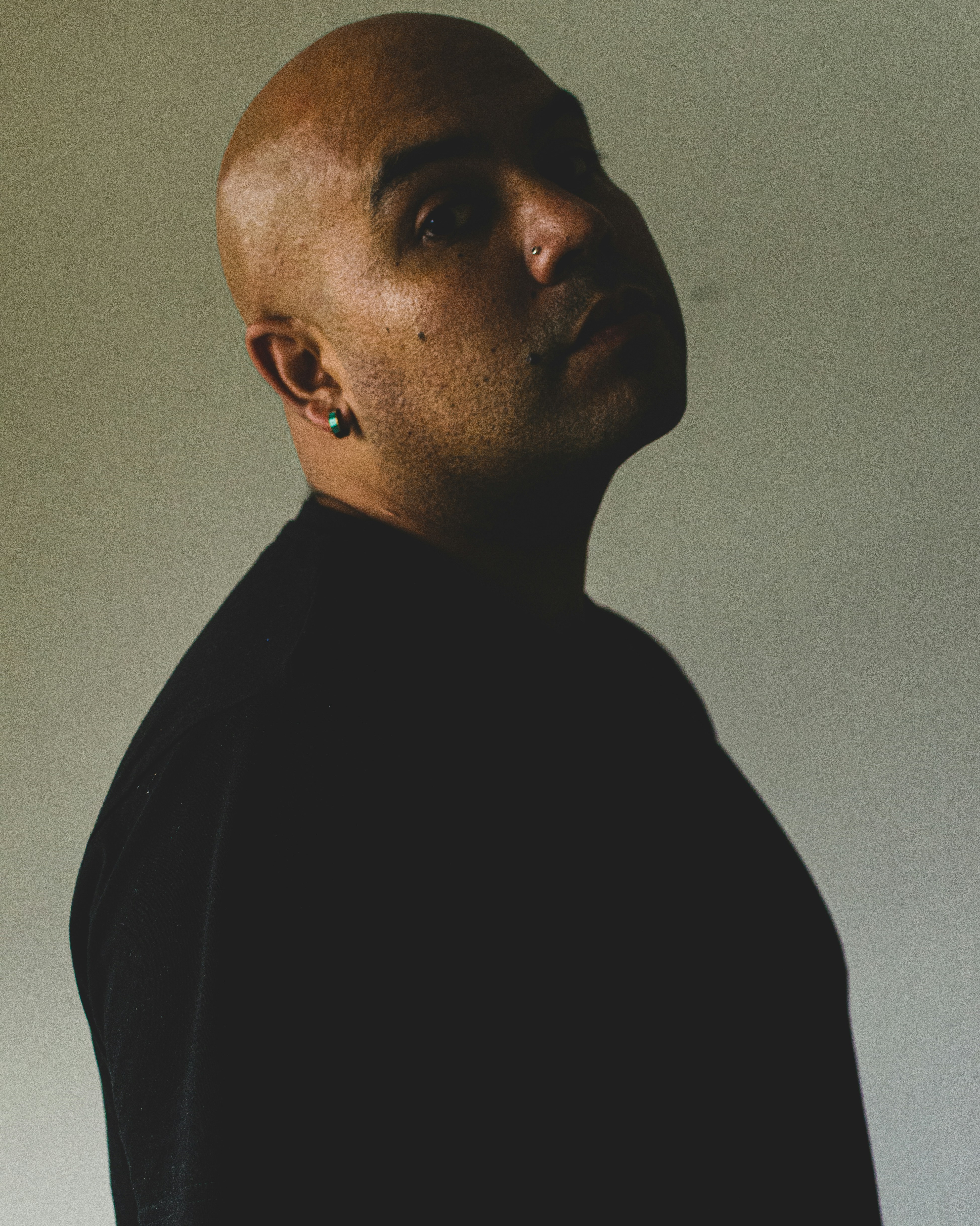Portrait | Bald man wearing a black t-shirt looking away