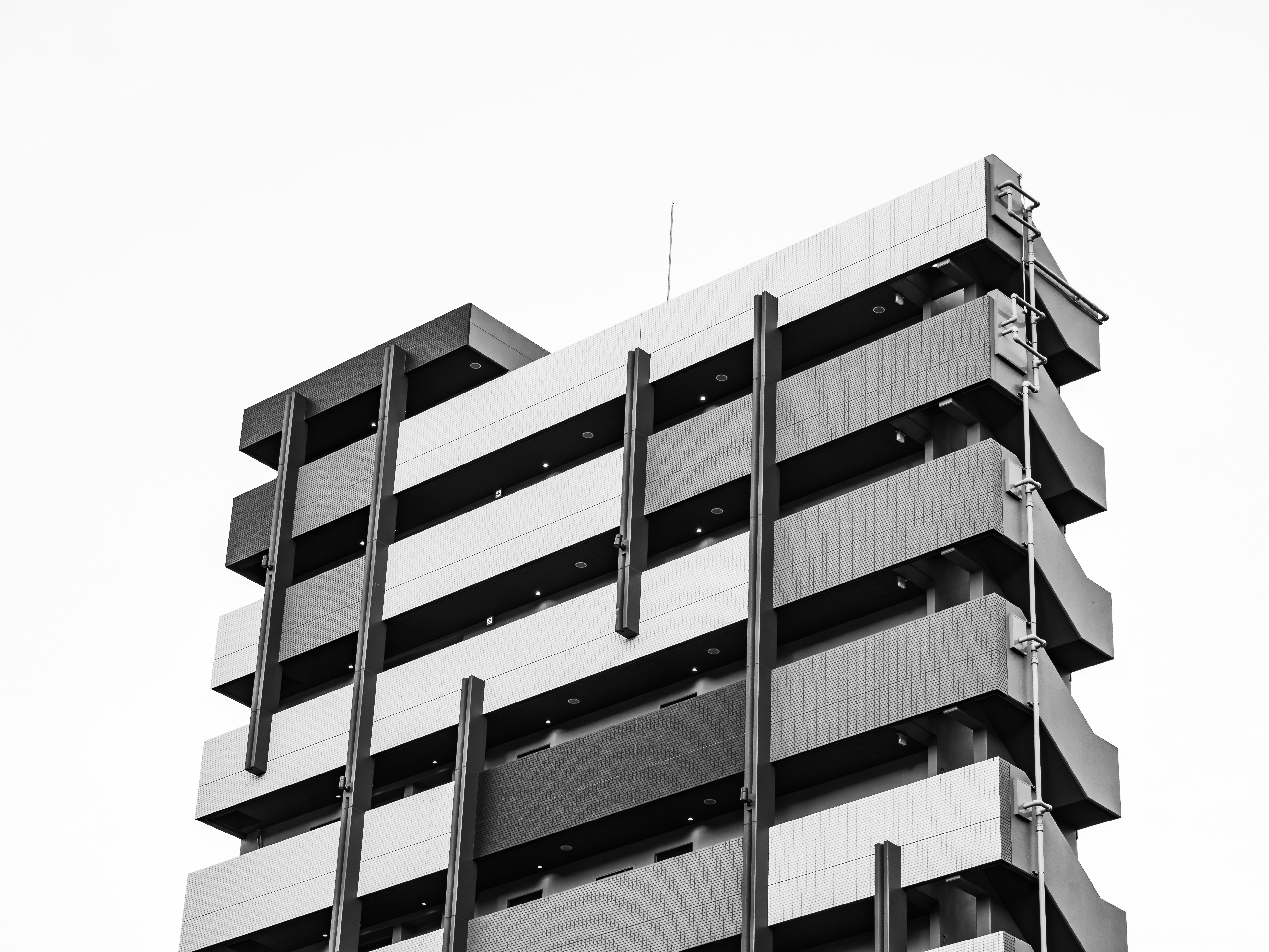 Modern architectural structure featuring bold lines and contrasting textures in black and white.